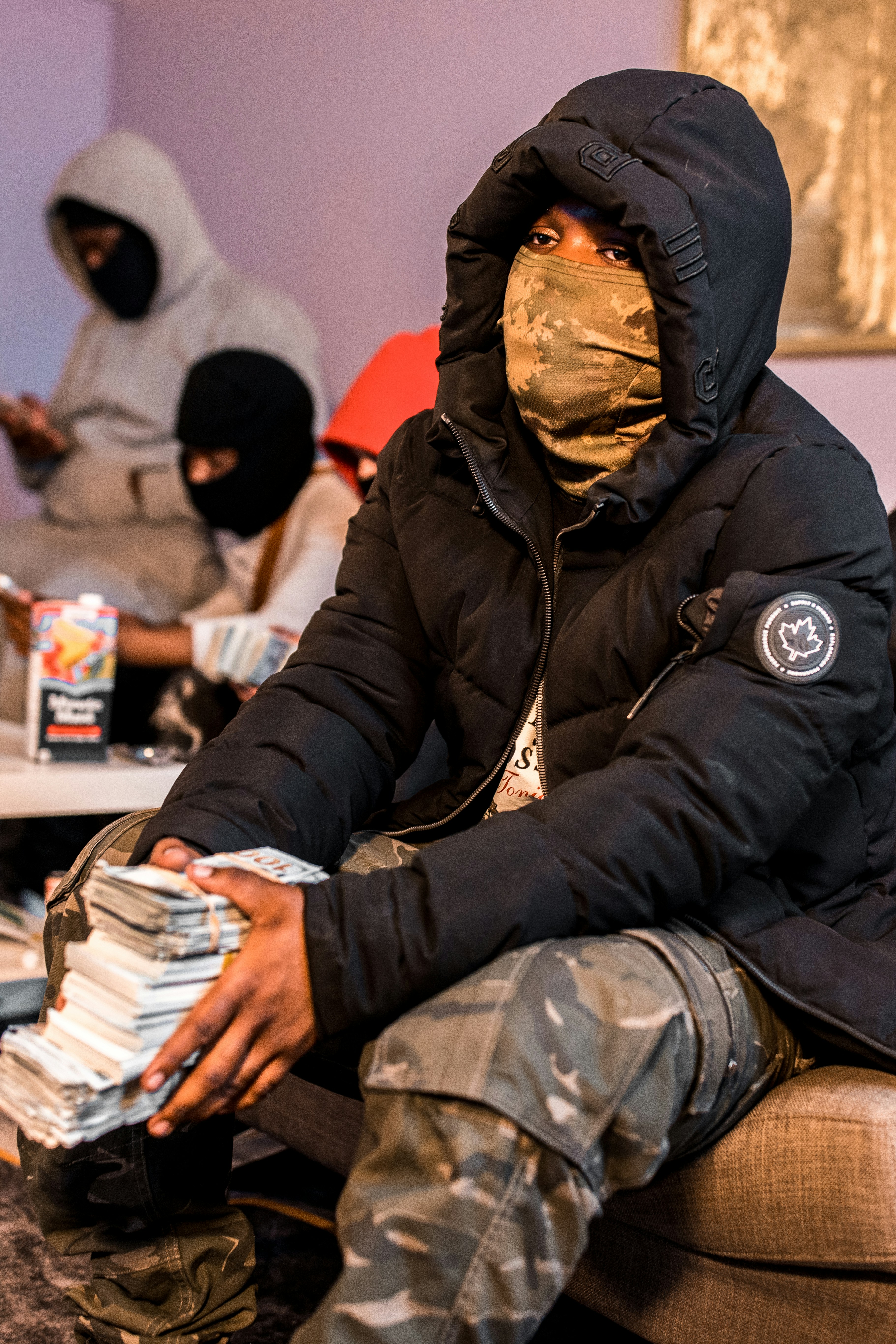 Stacks of Cash and Masked Figures: A Cold-Weather Portrait in a Hidden Room