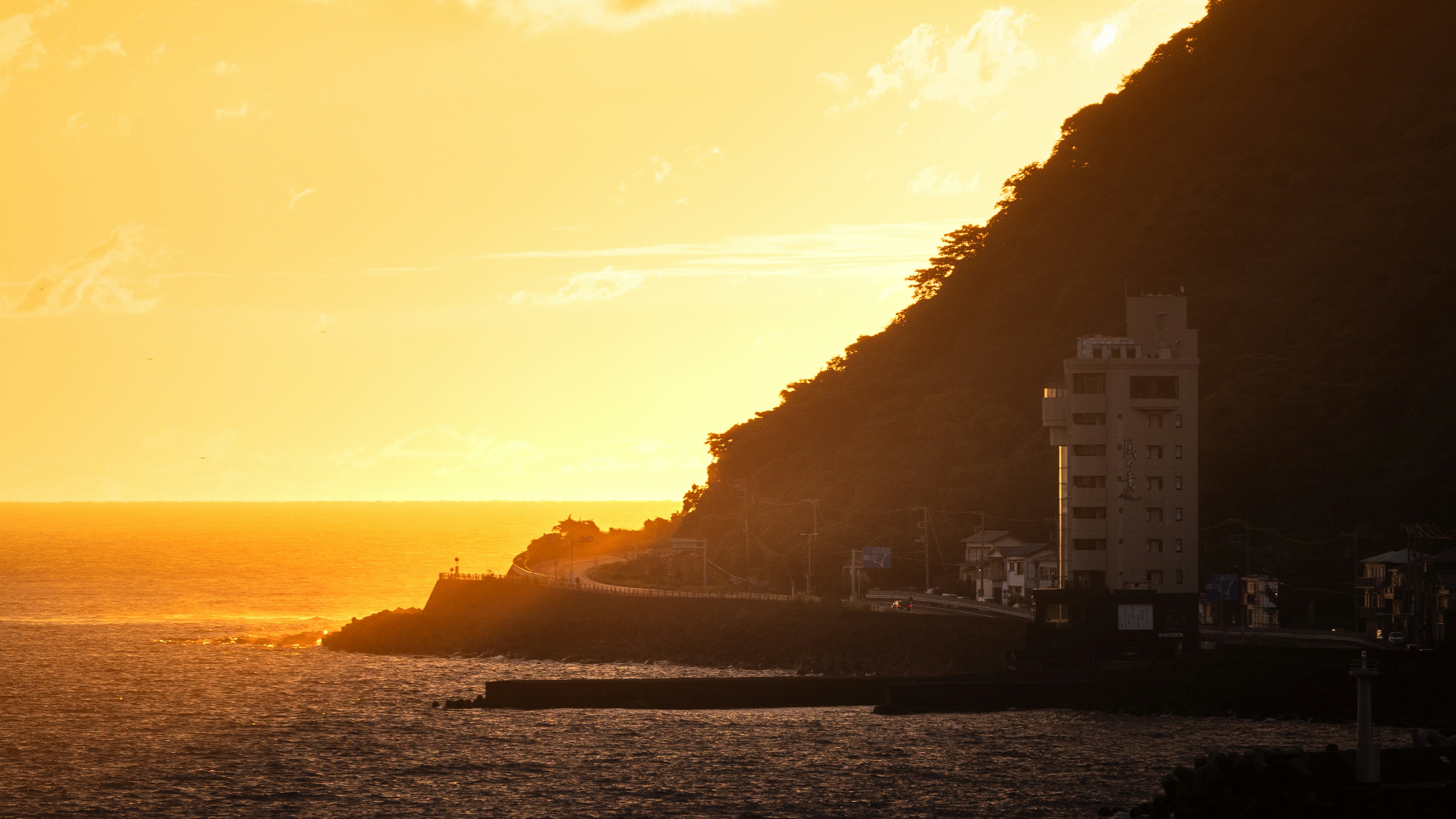 Sunlit Coastline: A Quiet Sunset Over the Harbor Toward the Cliffside High-Rloor