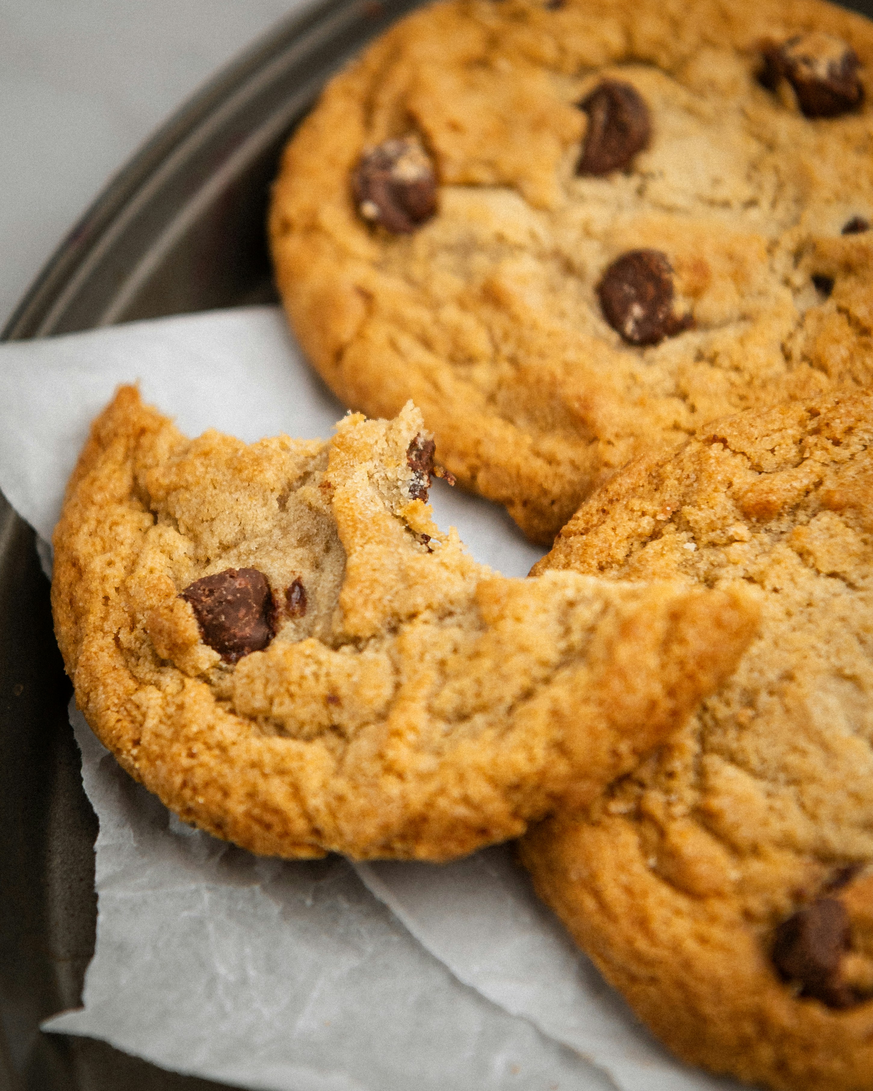 Sugared Moments: Close-Up of Chewy Chocolate Chip Cookies on a Crinkled Paper