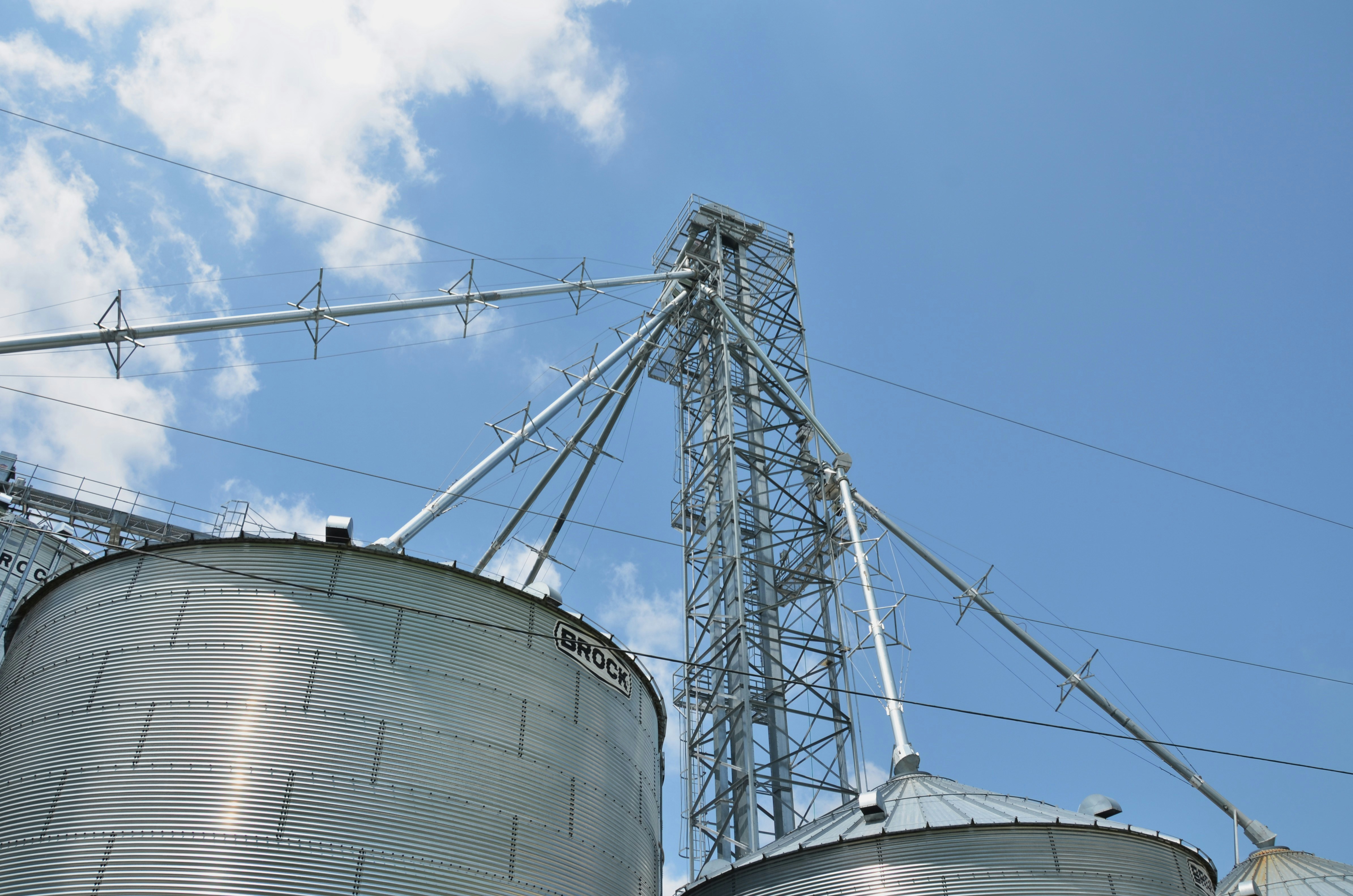 Industrial Sky: Silver Silos Under a Clear Blue Portrait