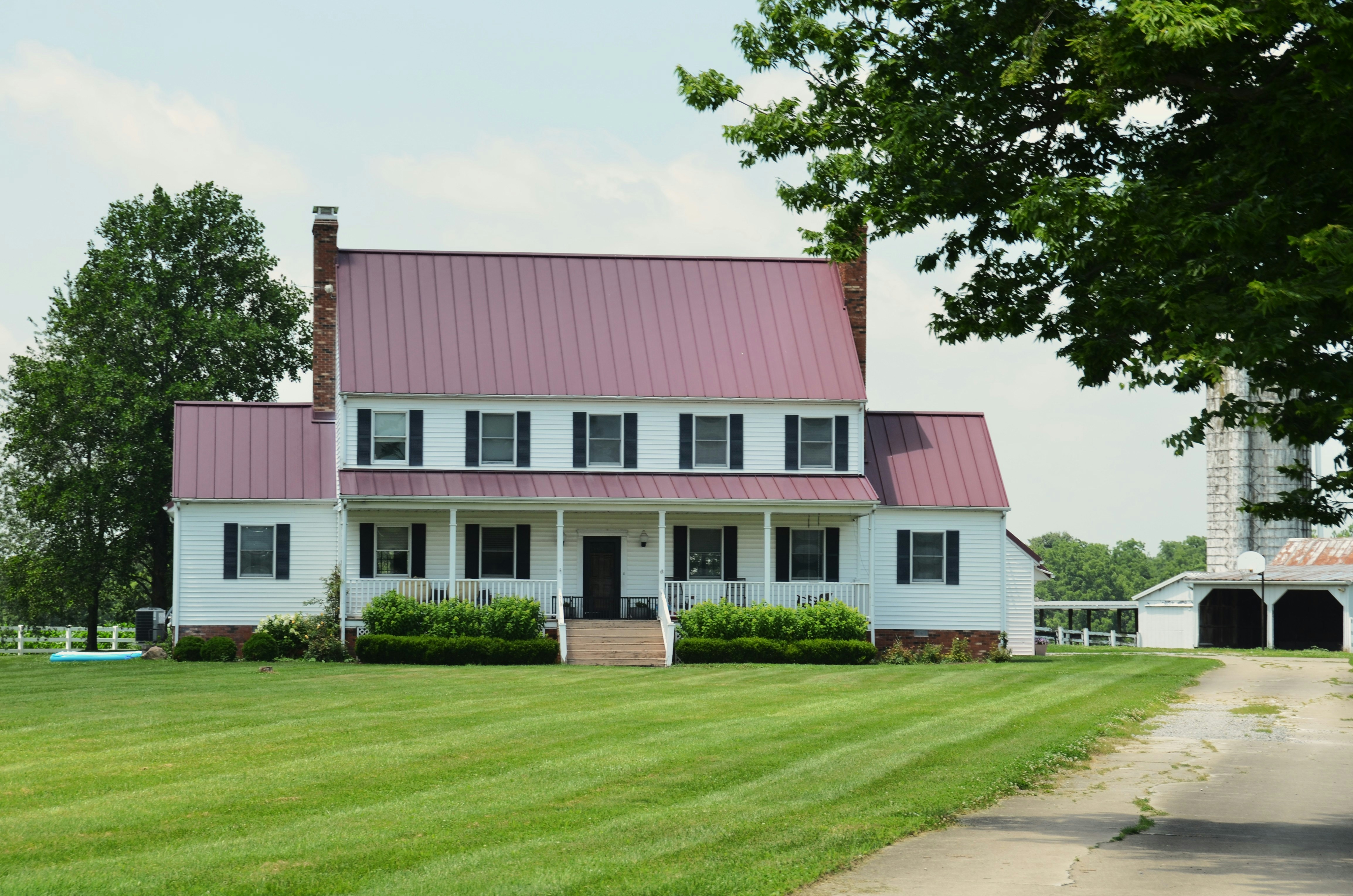 A Quiet Farmhouse Standing Guard over a Trim, Sunlit Lawn