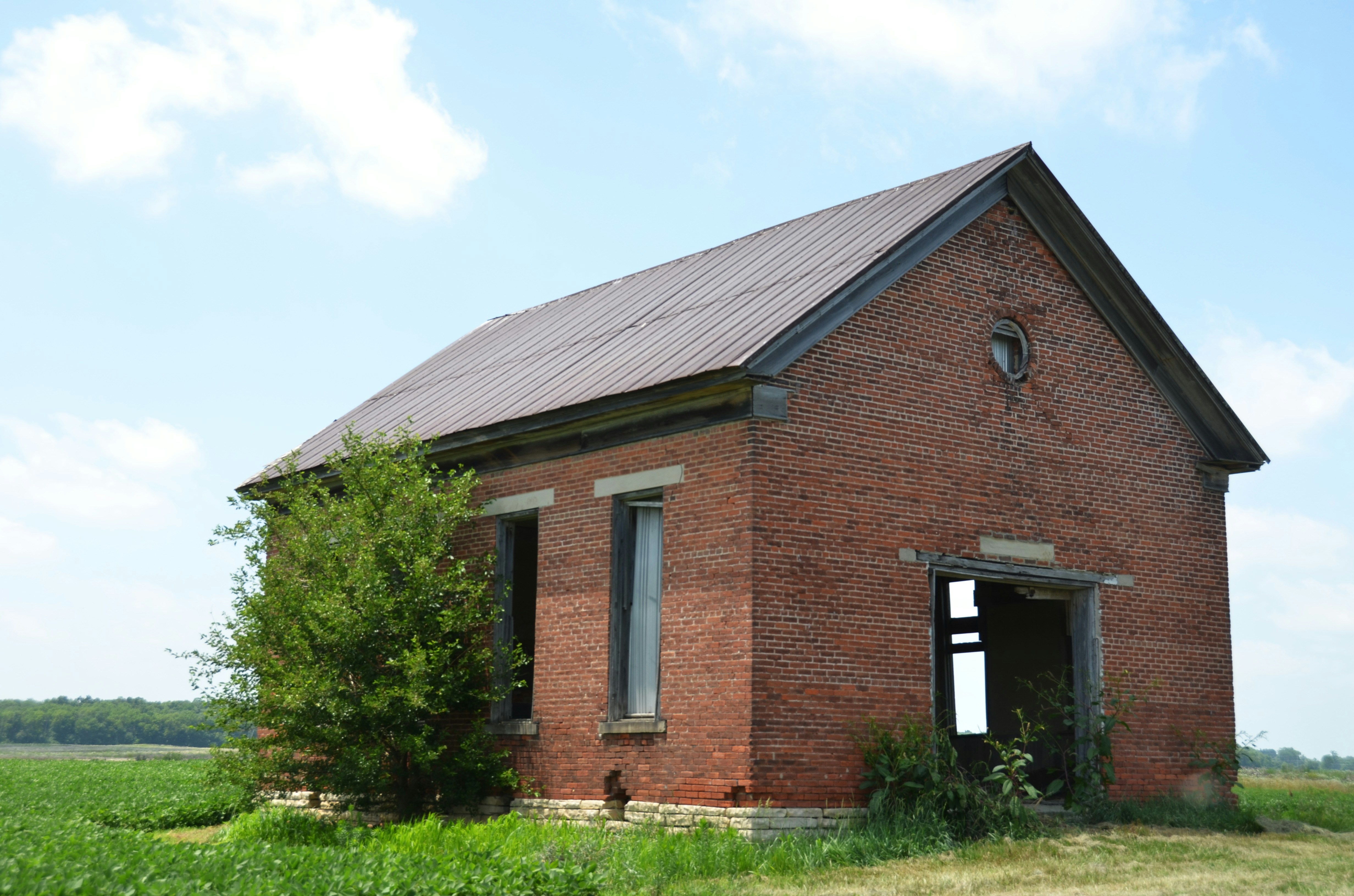 Red Brick Farmhouse Surrounded by Green Pasture