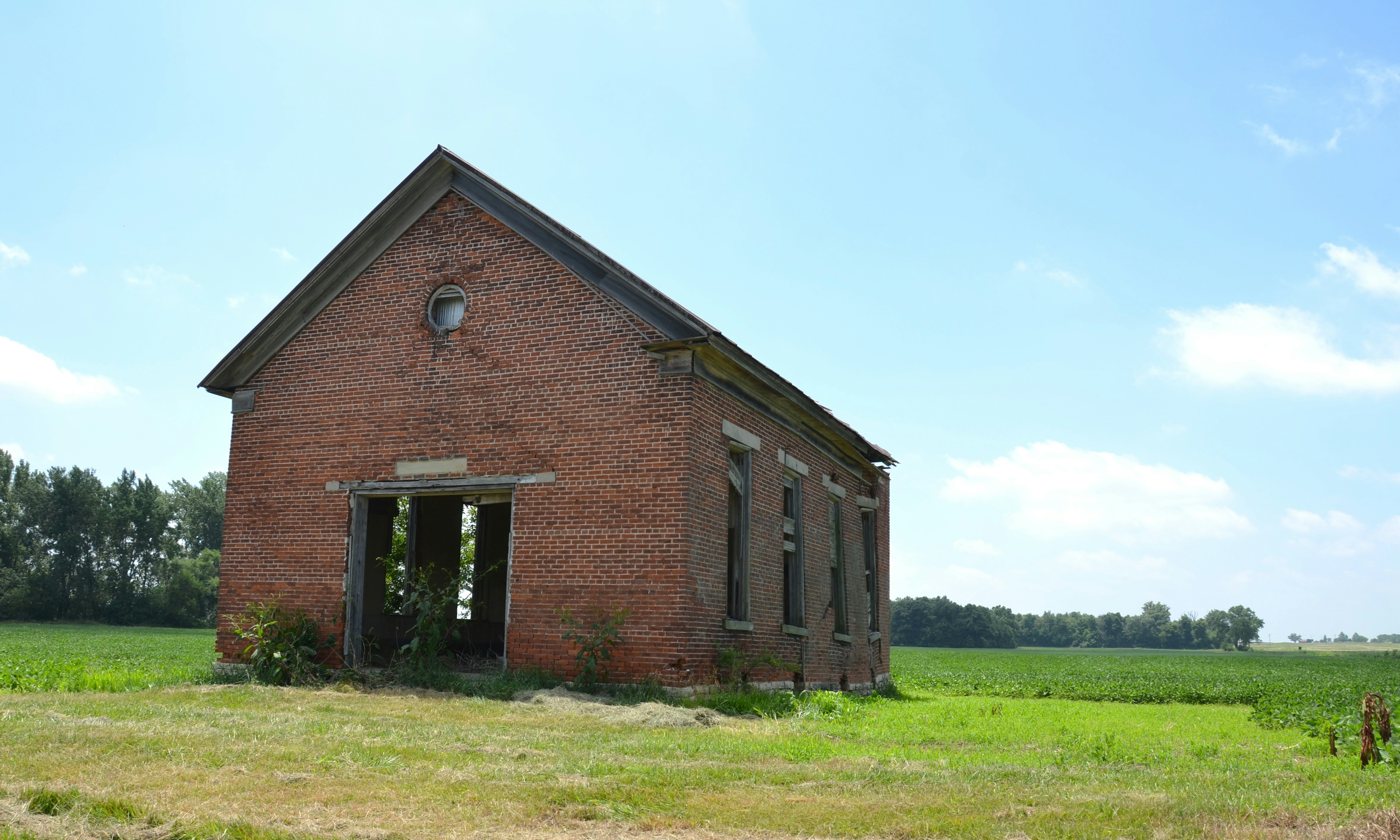 Brick Ruin in Open Fields Under a Bright Blue Sky