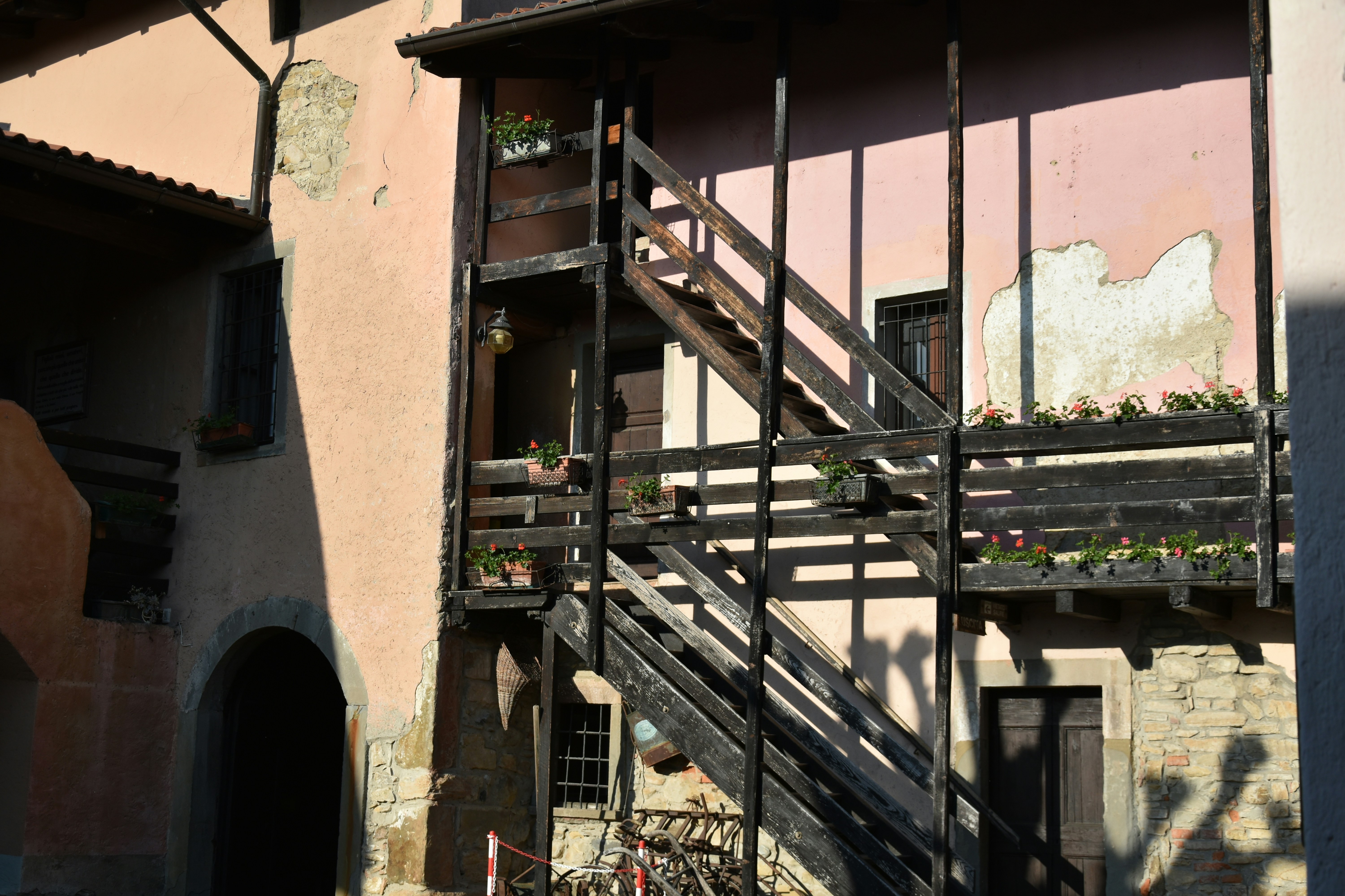 Sunlit Staircase Framed by Pale Facade and Flower Boxes