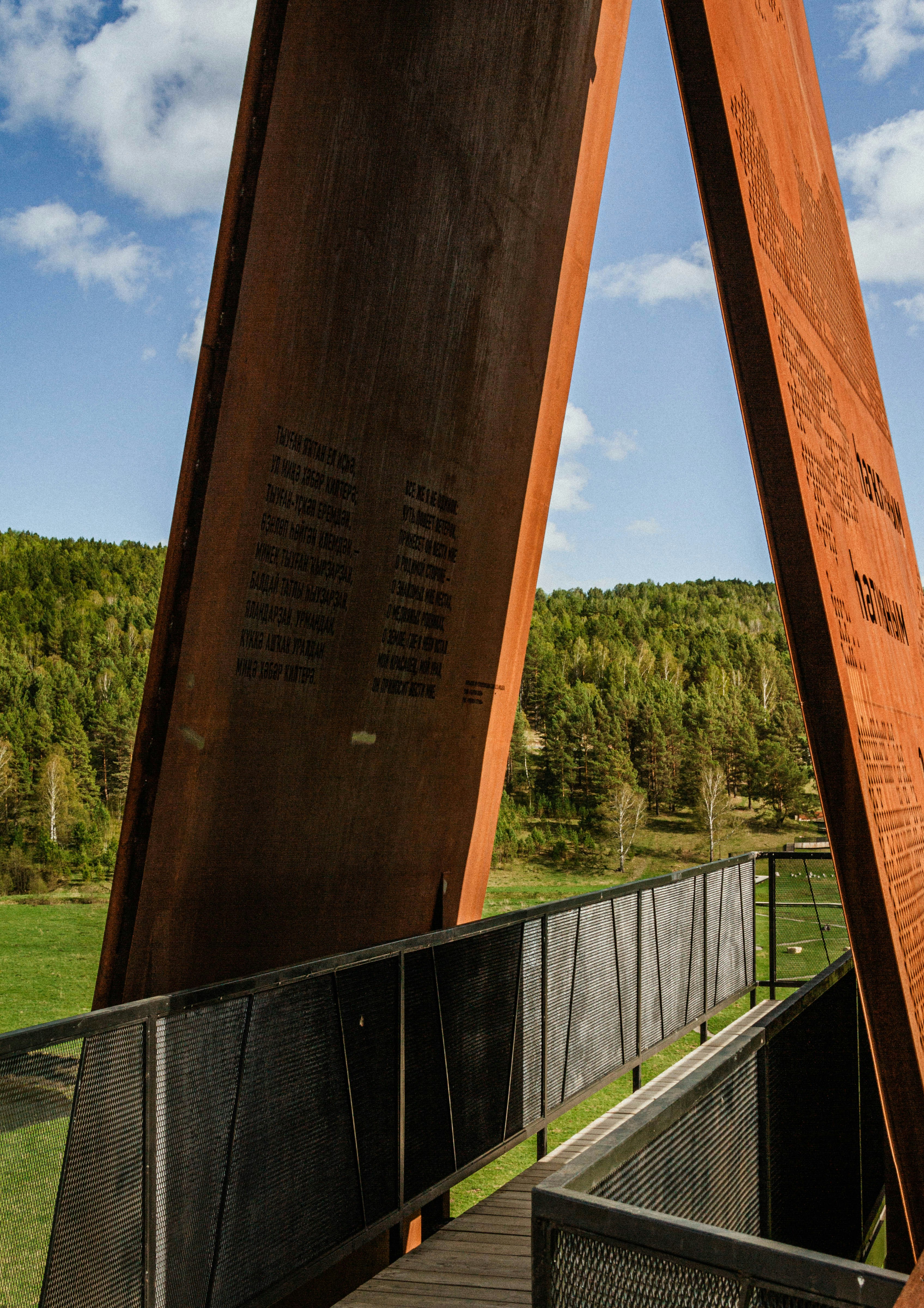 Iron Gate to the Plains: A Rusted Arch Framing a Green Valley