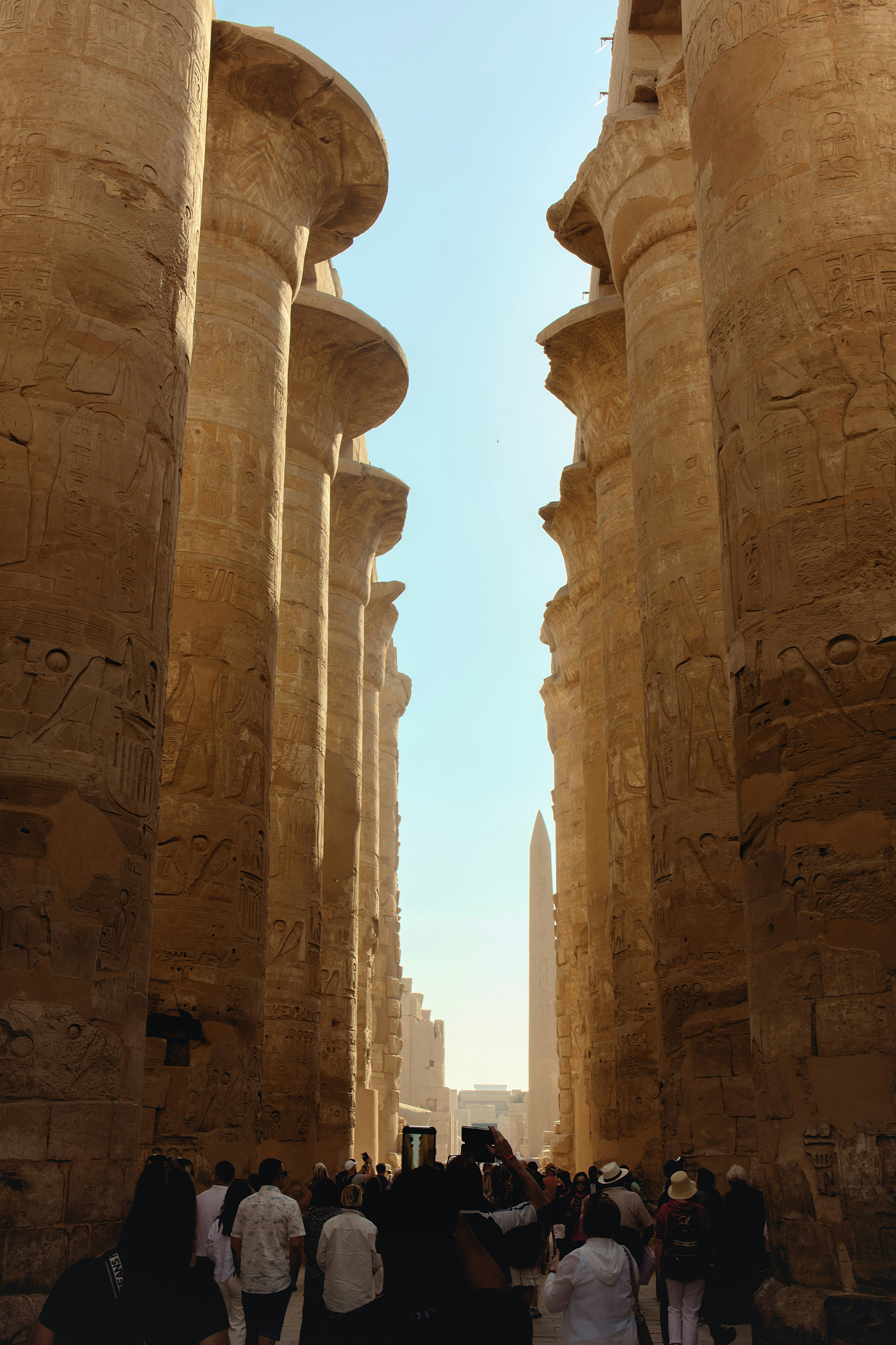 Between Giants: A Street of Immense Columns Looming Over a Crowded Passage