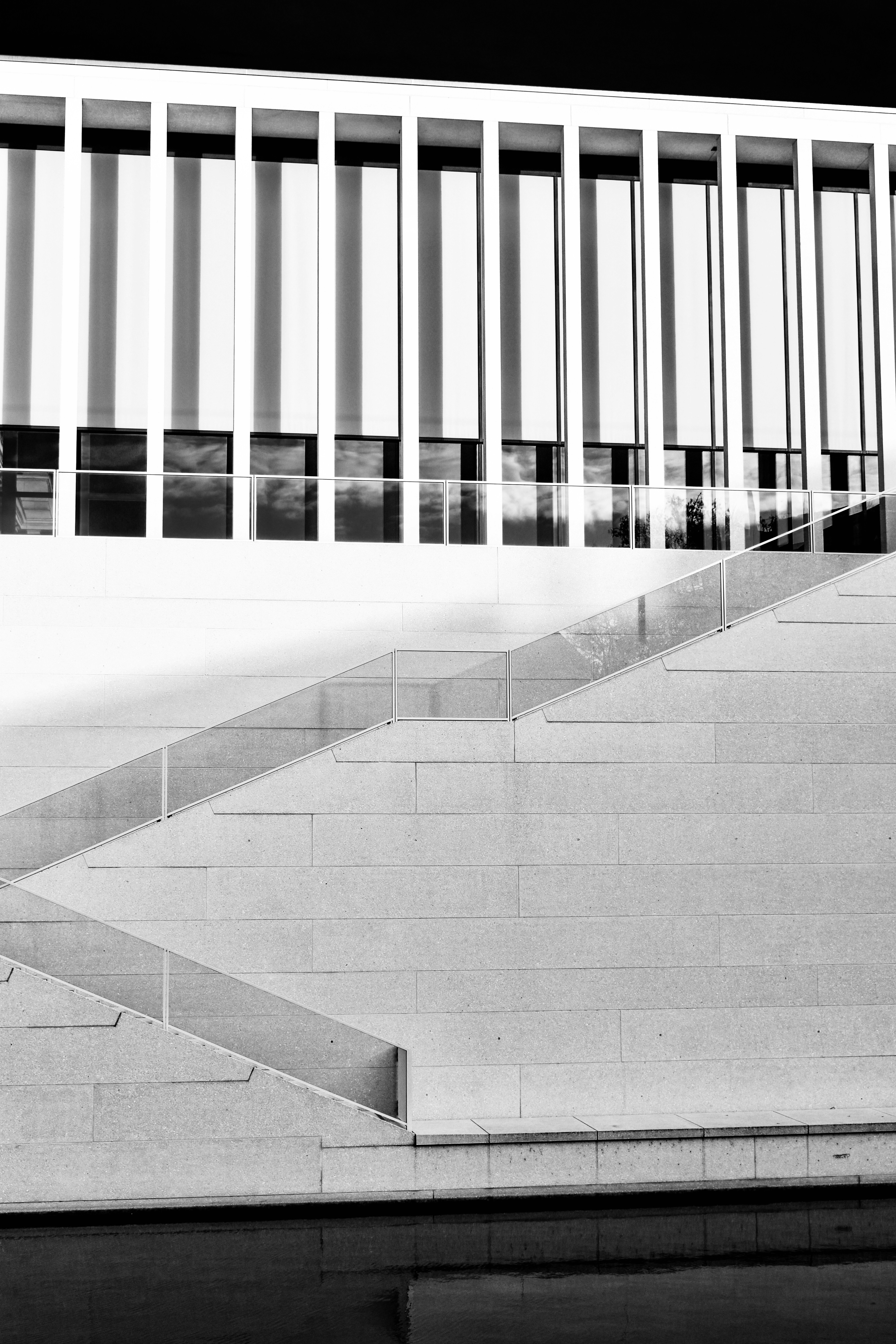 Linear Echoes: A Monochrome Staircase and Glass Facade