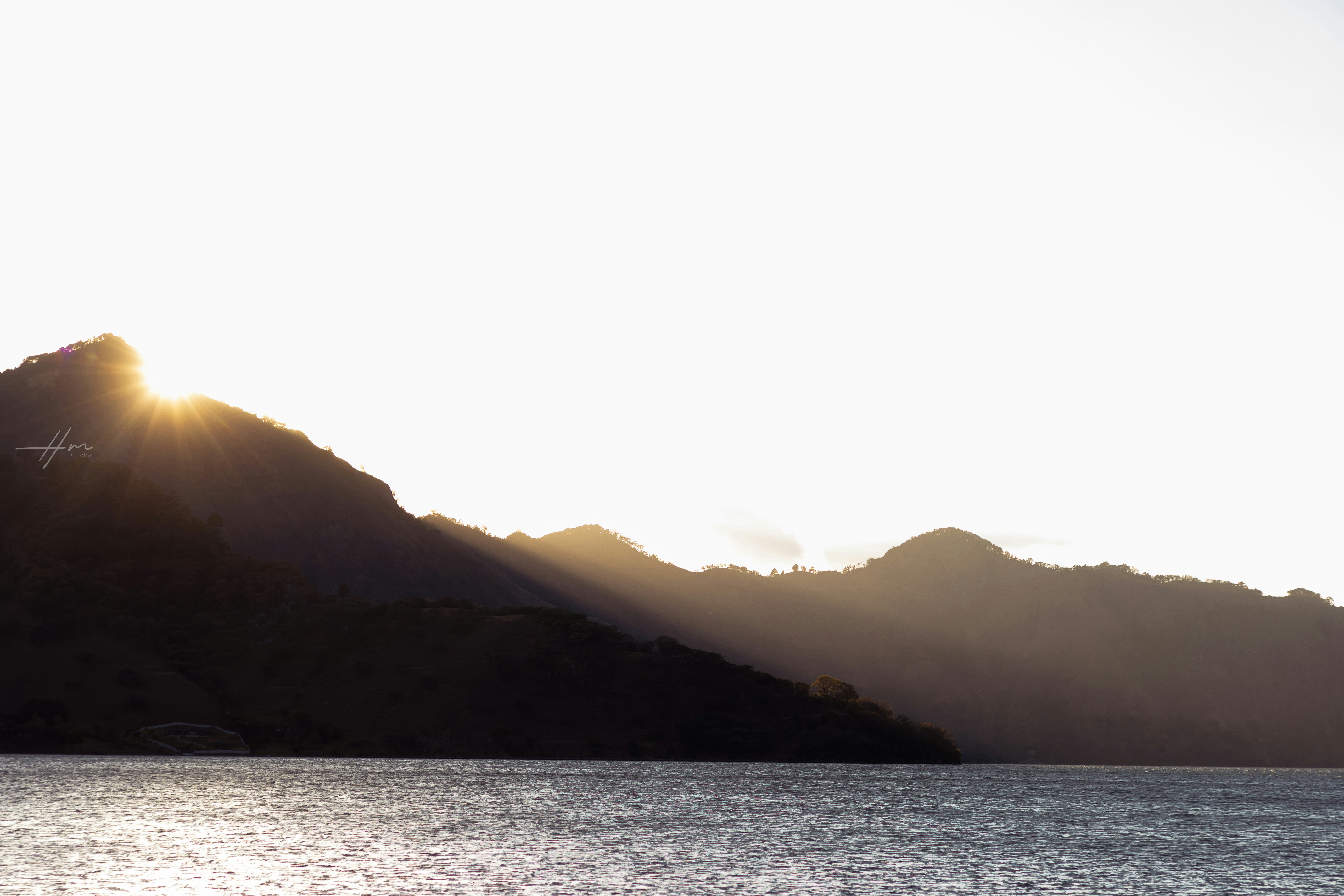 Dawn over the Quiet Ridge: Sunlit Silhouette by the Water