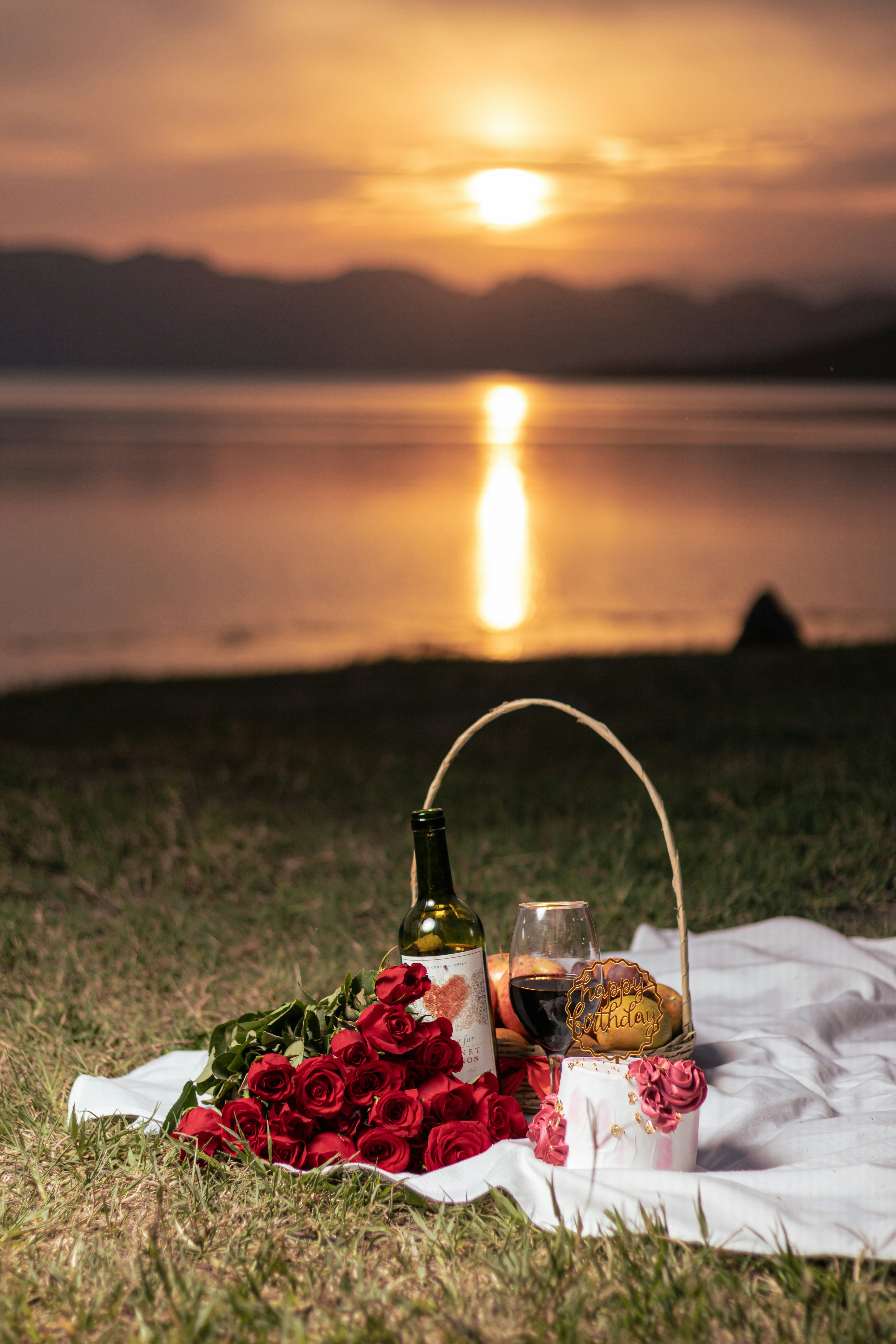 Sunset Serenade: A Picnic of Roses and Wine by the Water