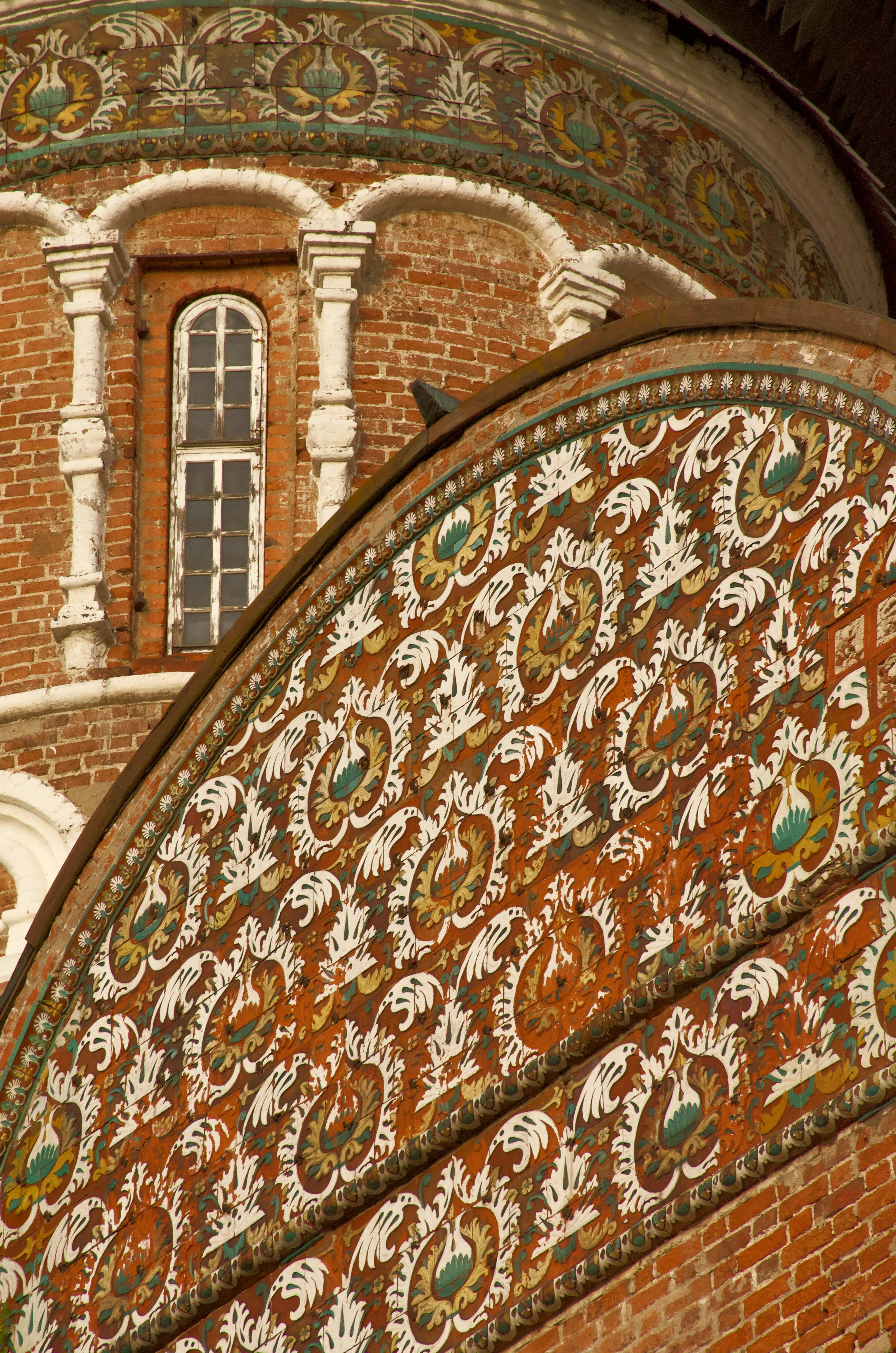 Curved Mosaic: A Brick Archway Adorned with Whorled Florals