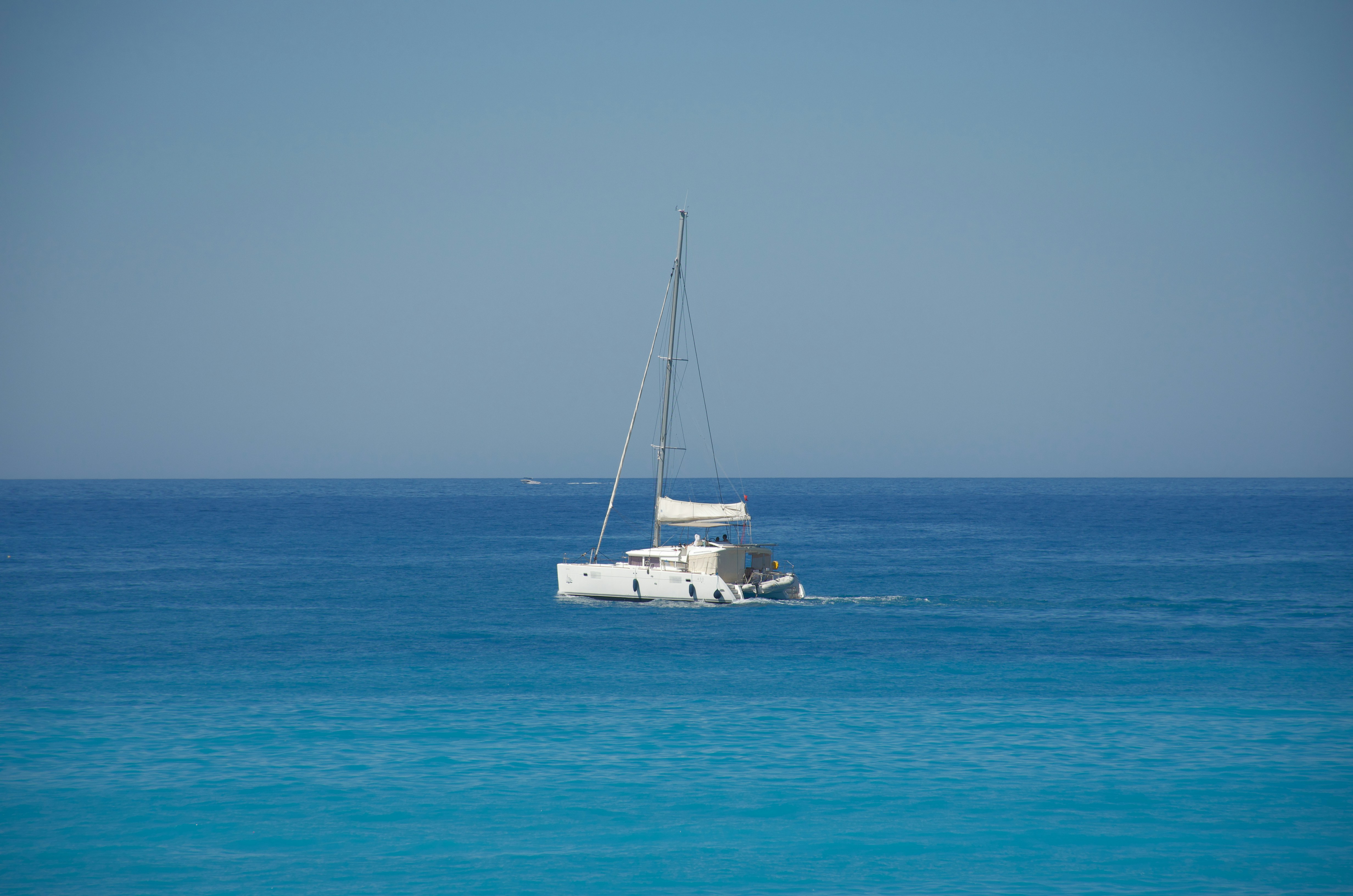 Sailing Silhouette: A Lone Catamaran on a Serene Sea