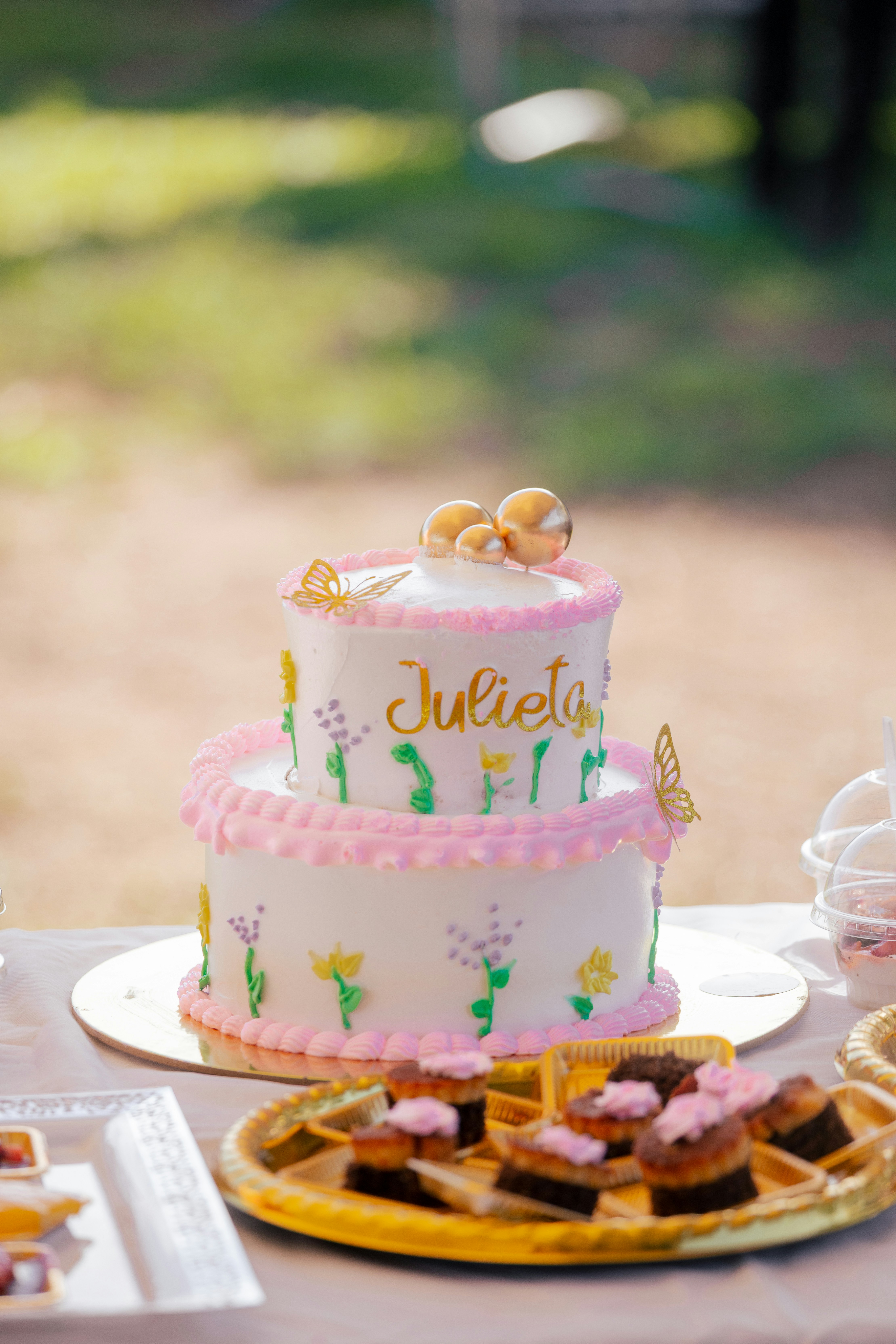 Pastel birthday tower: a two-tier cake crowned with golden spheres