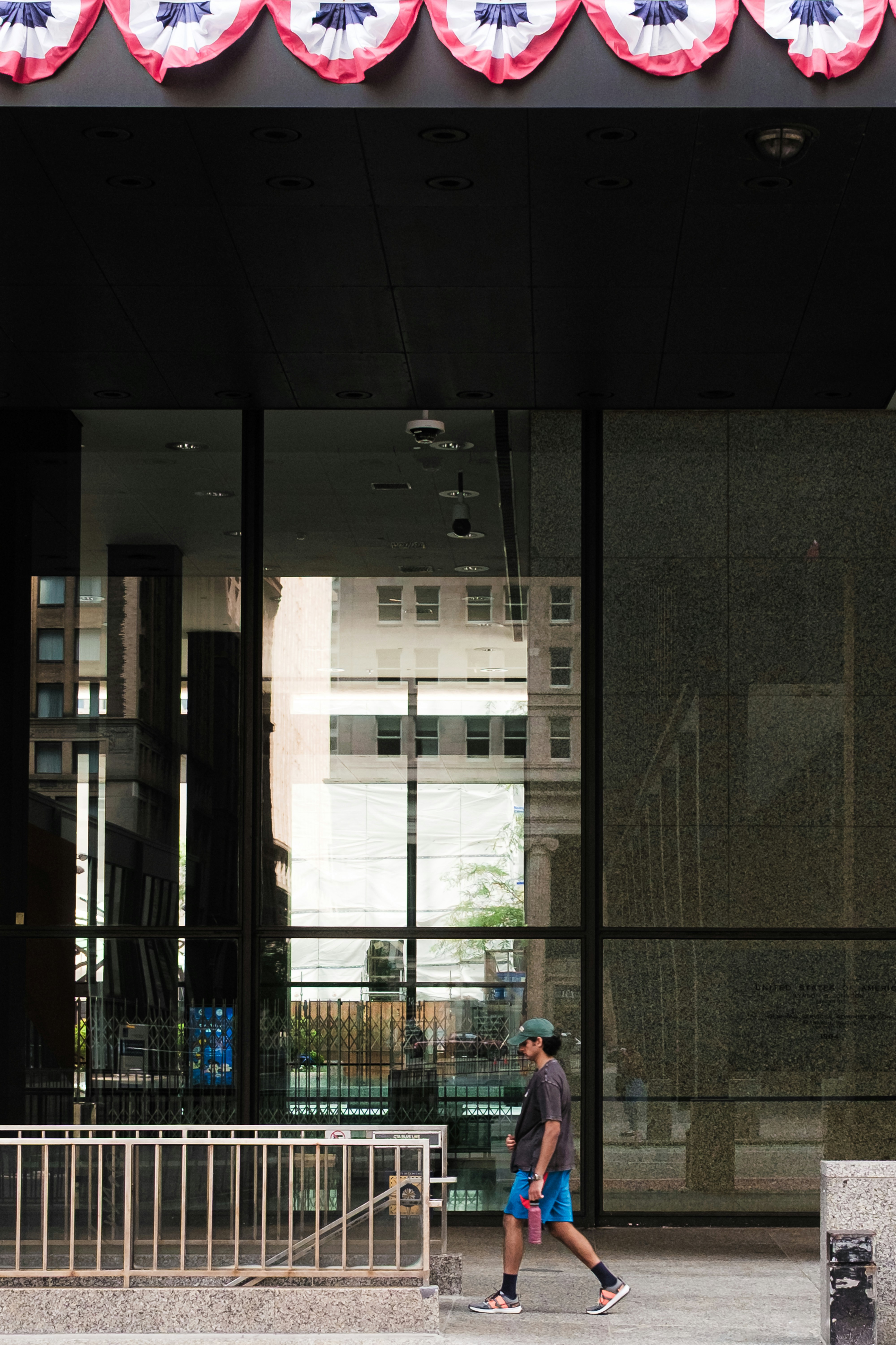 Urban Walk: A Solo Pedestrian Stirs Quiet Rhythm in a Glassy City Facade