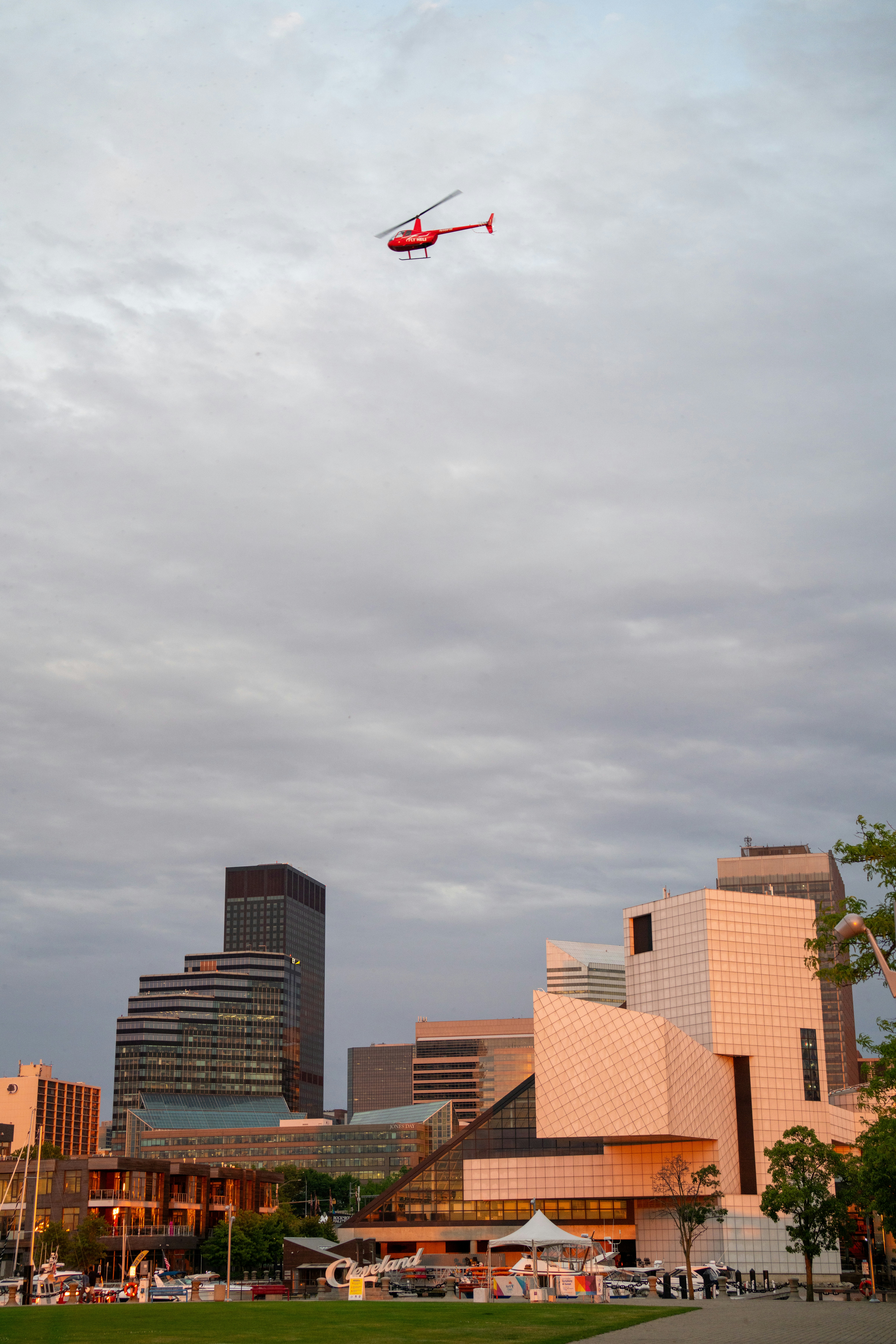 Red helicopter over a modern cityscape at golden-hour