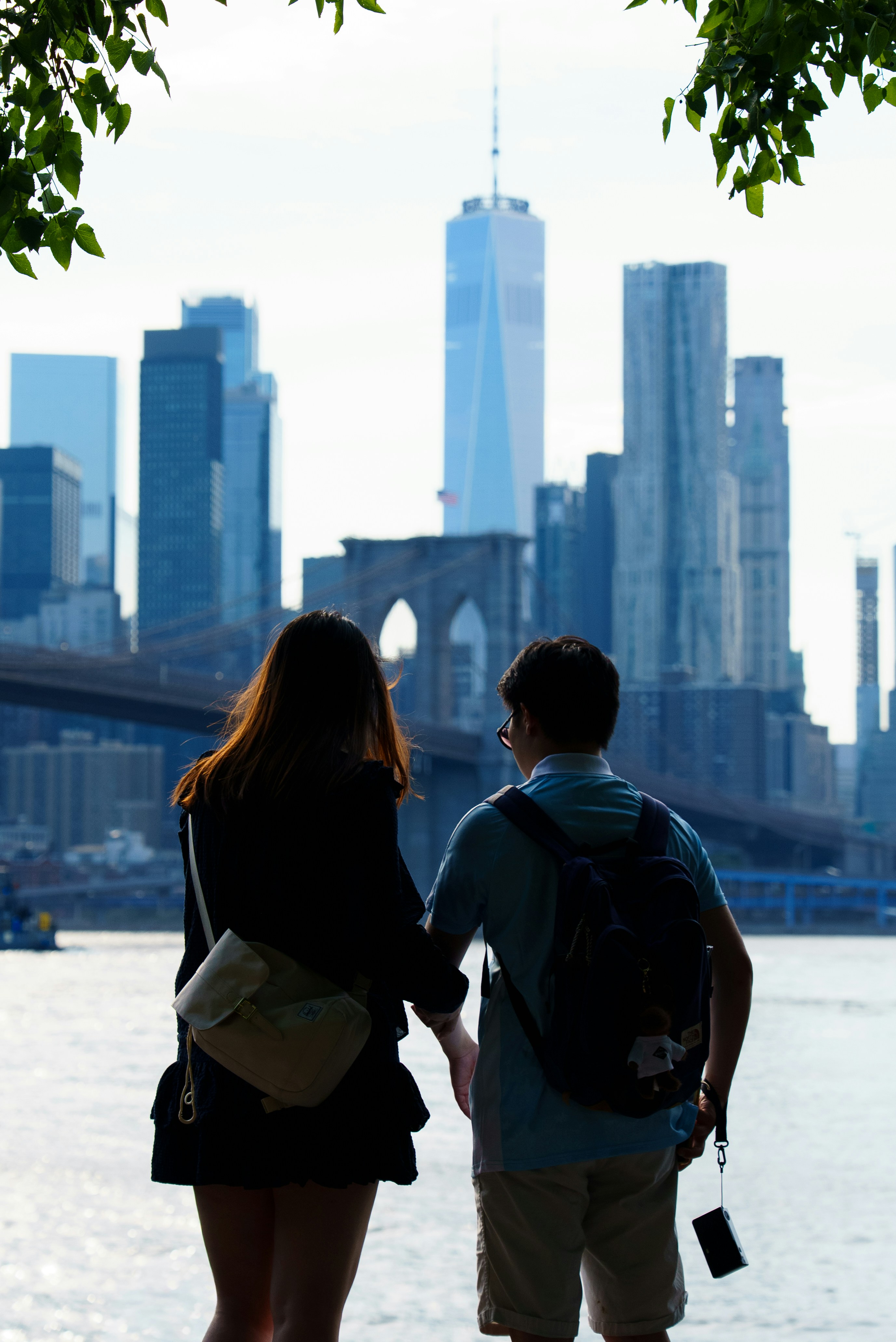 A Quiet Moment by the Brooklyn Bridge: Two Passersby in Silhouette