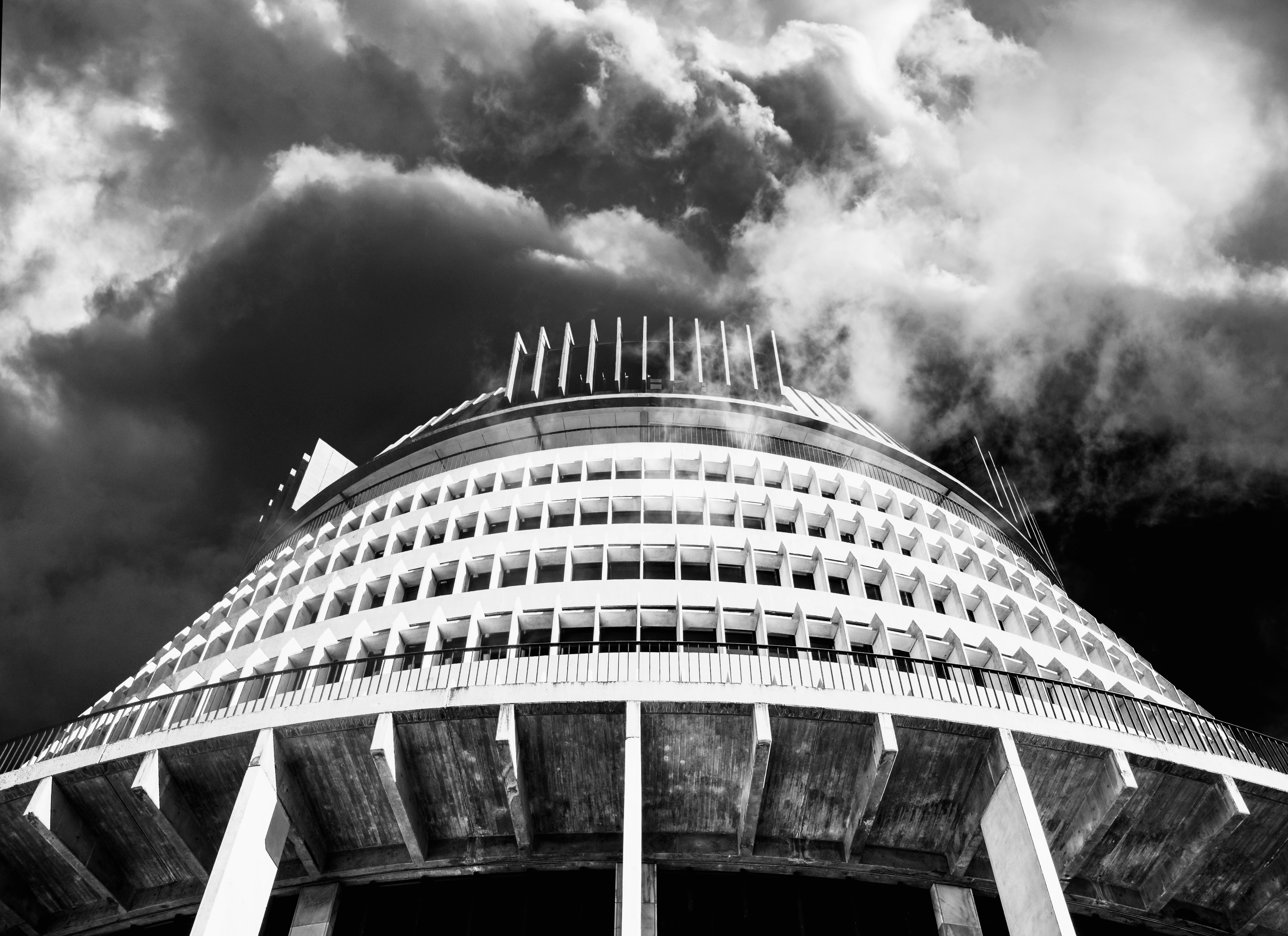 Conical tower of light and shadow rising through stormy skies