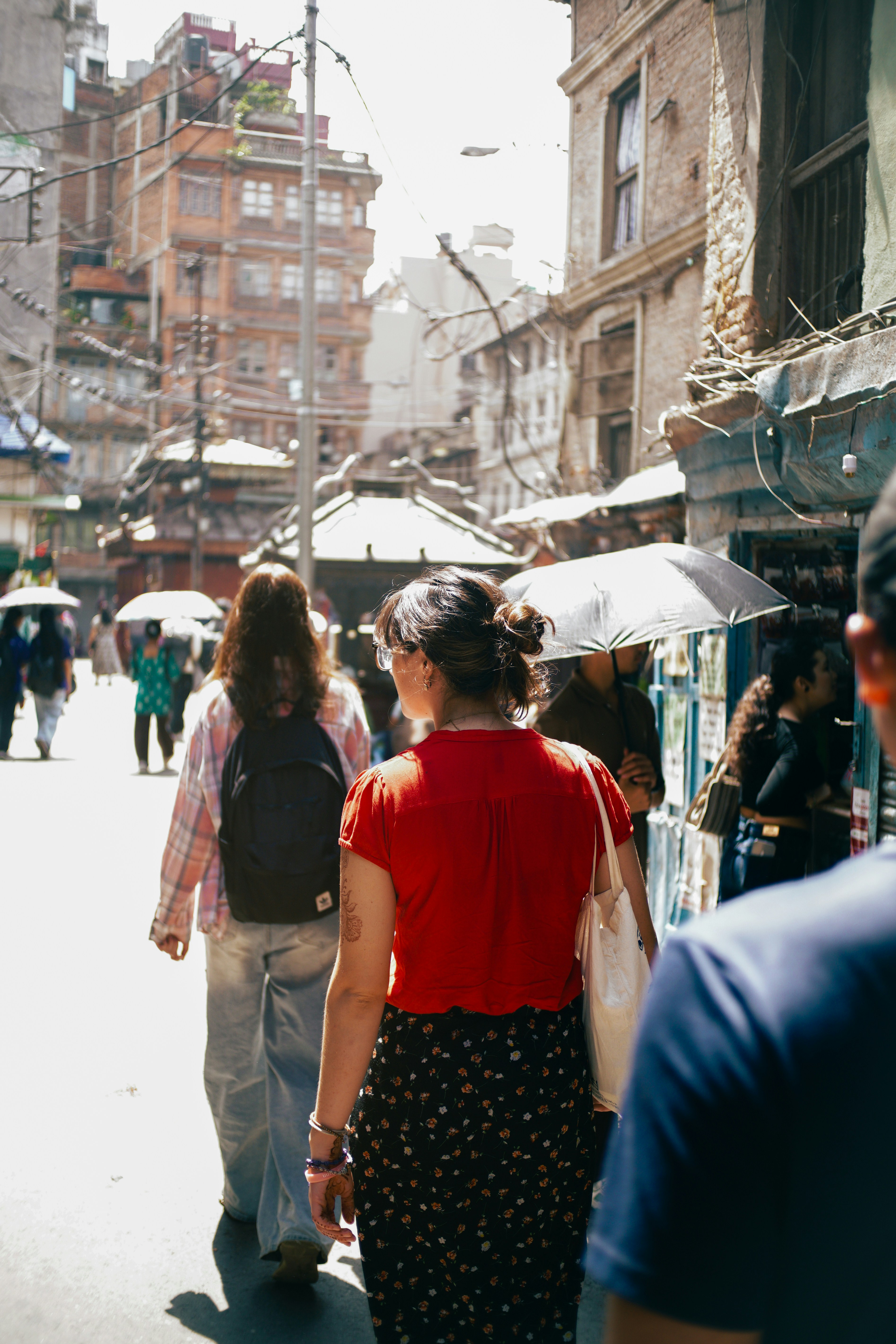 Red Heron in a Sunlit Alley: A Crowd-Focused Street Portrait