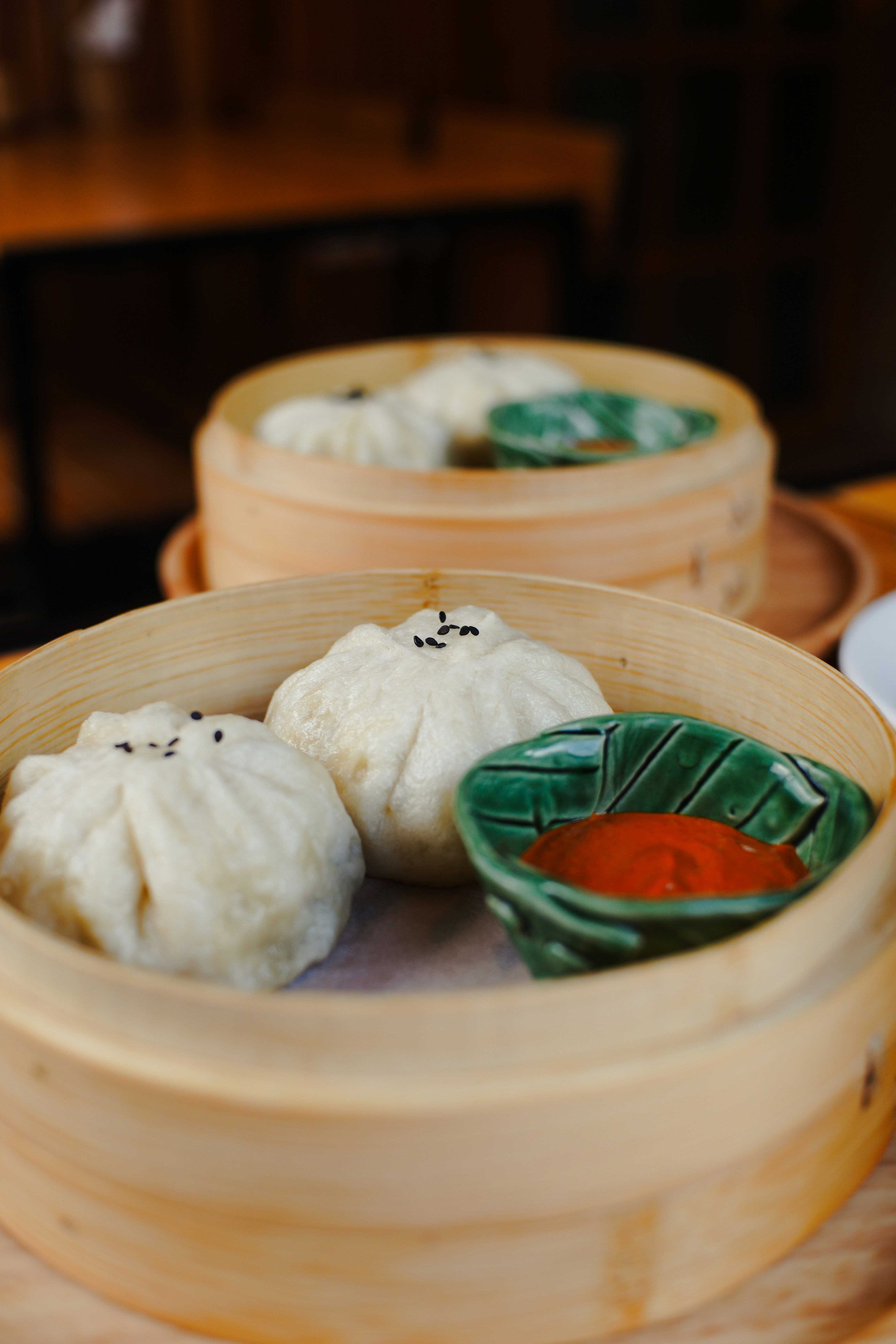 Steamed Dumplings in a Wooden Basket with a Sesame-Goop Dip