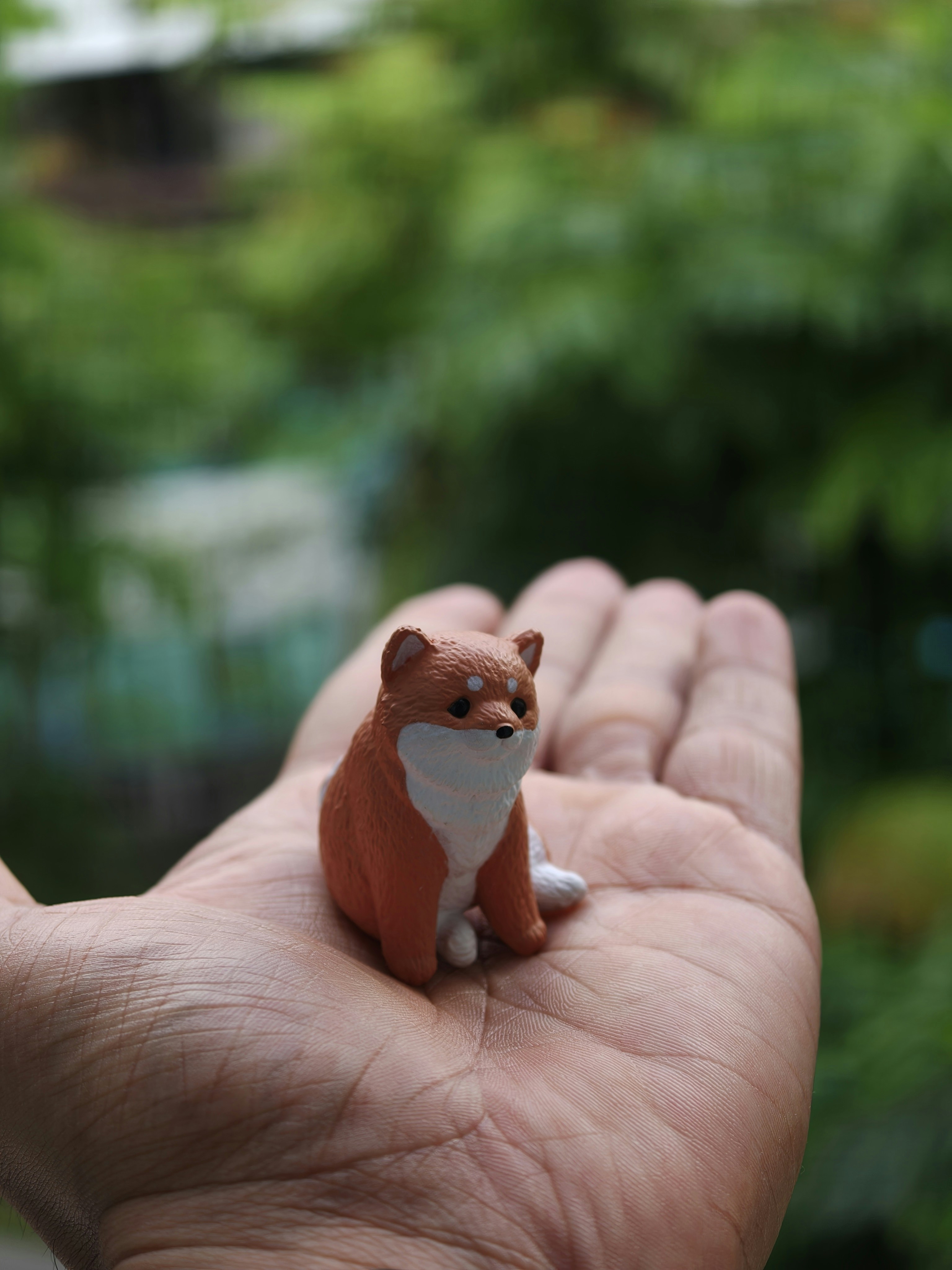 Tiny Red Fox Figurine Resting in an Open Palm