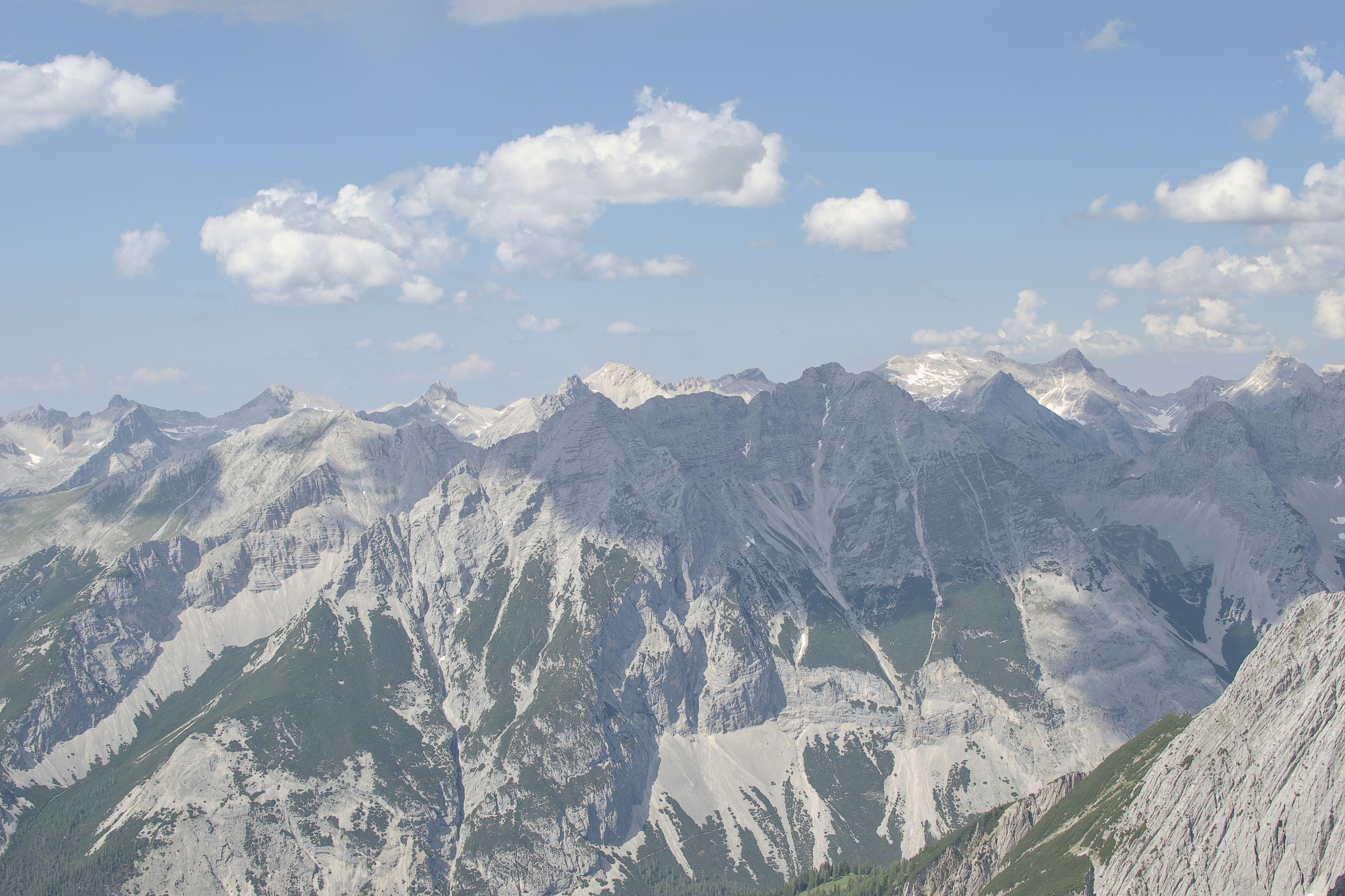 Skyline of jagged Alps under a cotton-blue sky