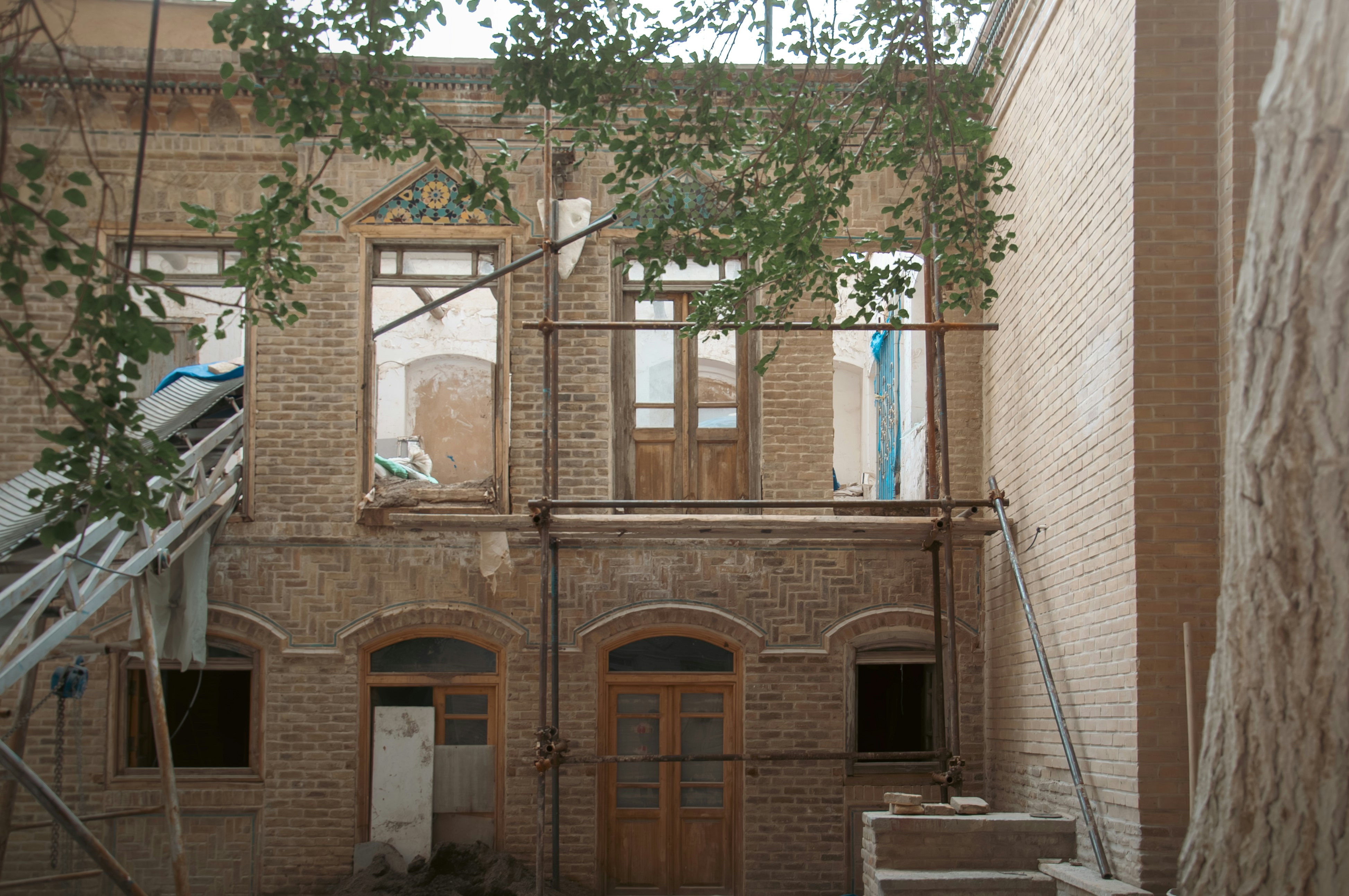 Courtyard of a Ruined Brick House with Green Foliage