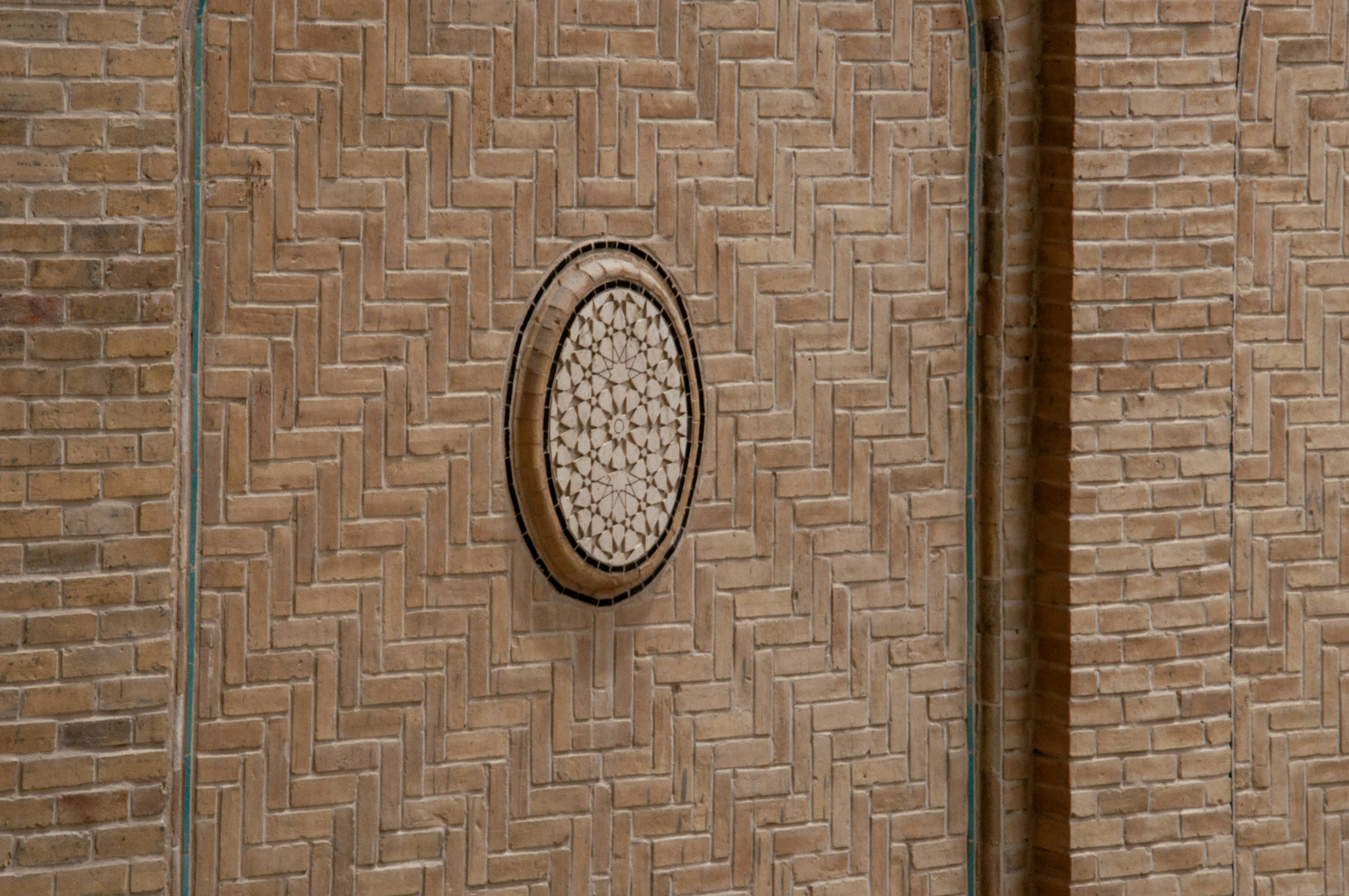 Circular Stone Mosaic Framed by Herringbone Brickwork