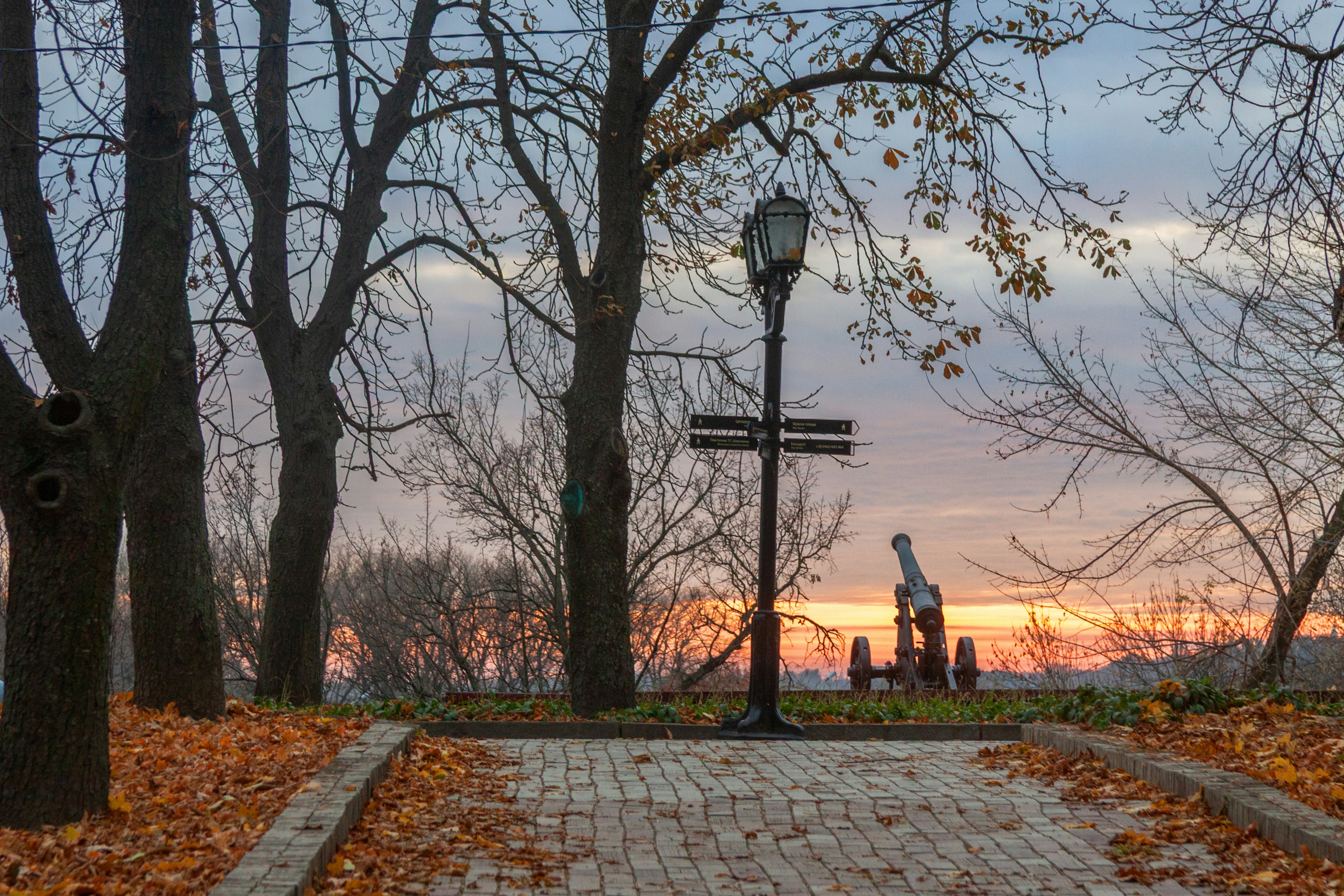Sunset Boulevard in the Park: Lanterns, Path, and Statue Silhouettes