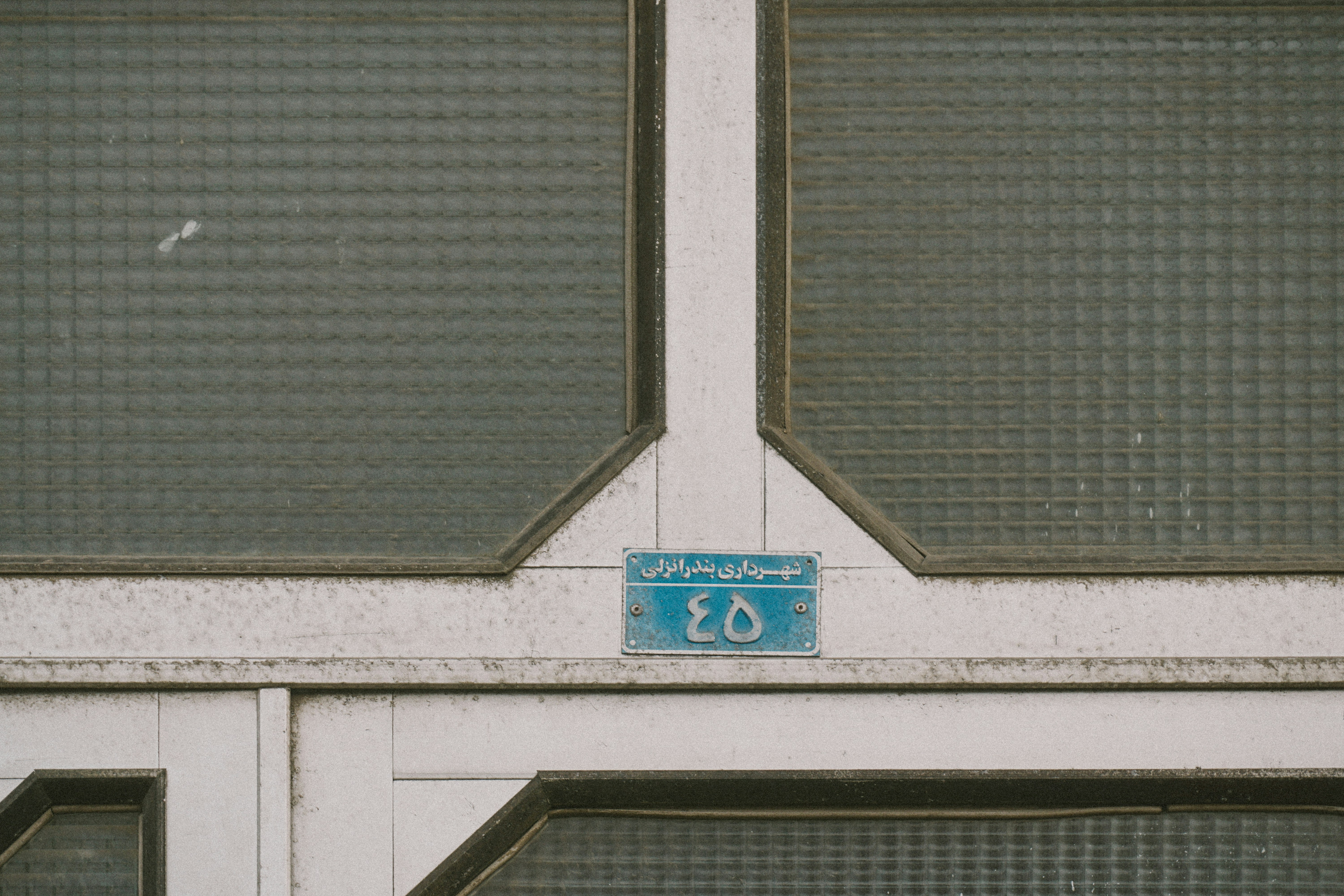 Blue Number Plate Framed Between Triptych Glass Windows