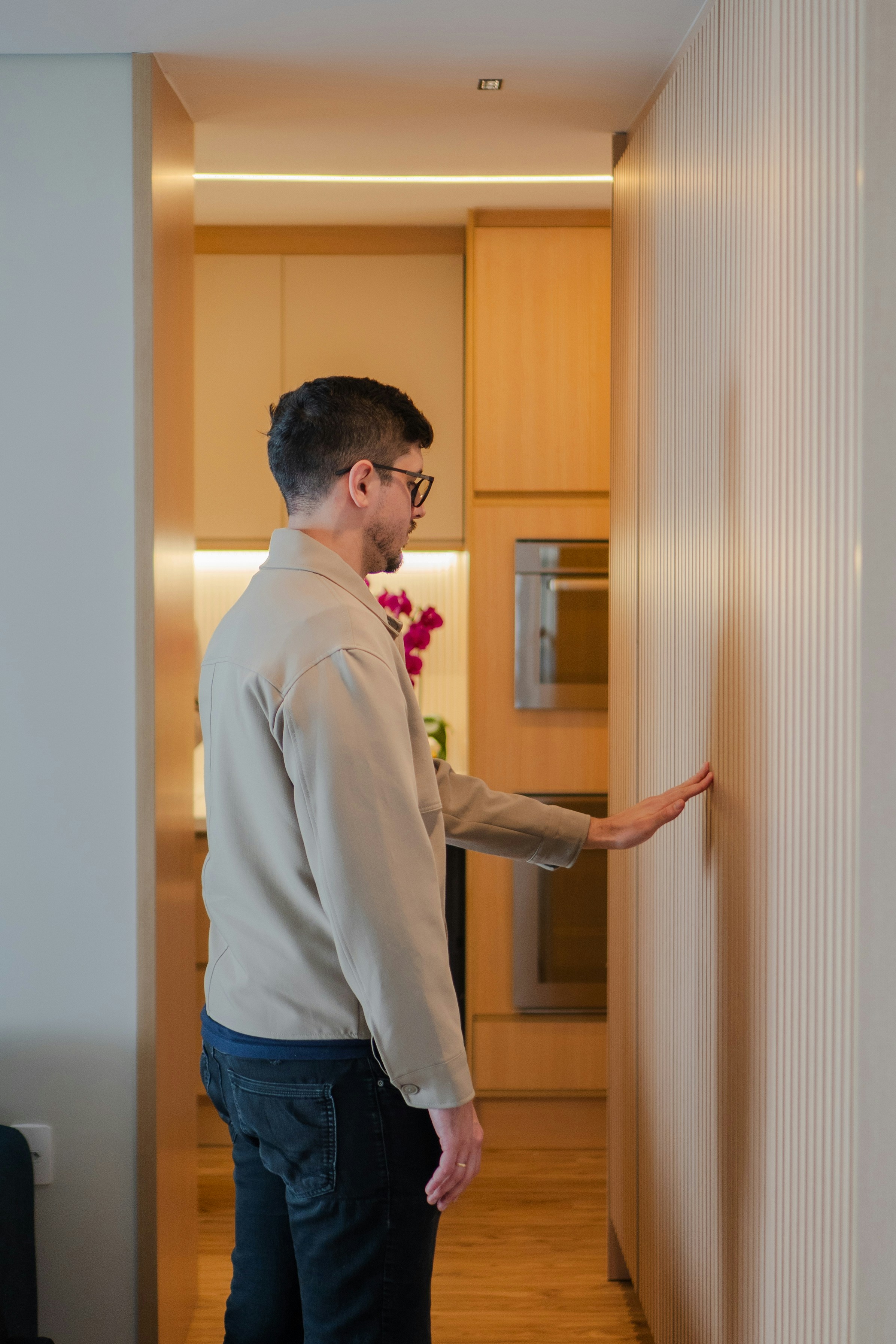 Gesture of Contemplation in a Modern Kitchen Hallway