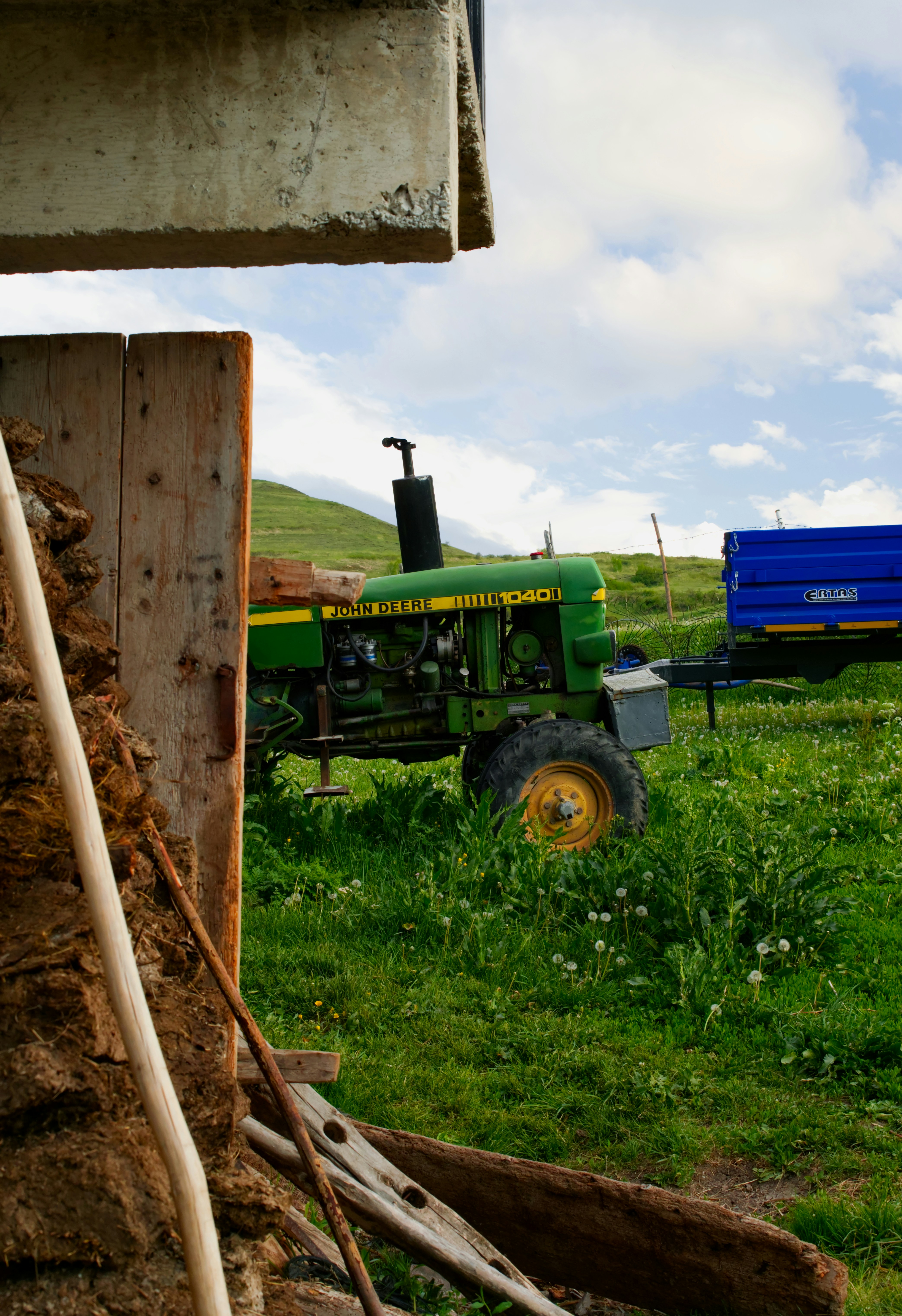Green John Deere Tractor at the Edge of a Pasture, Under a Concrete Beam
