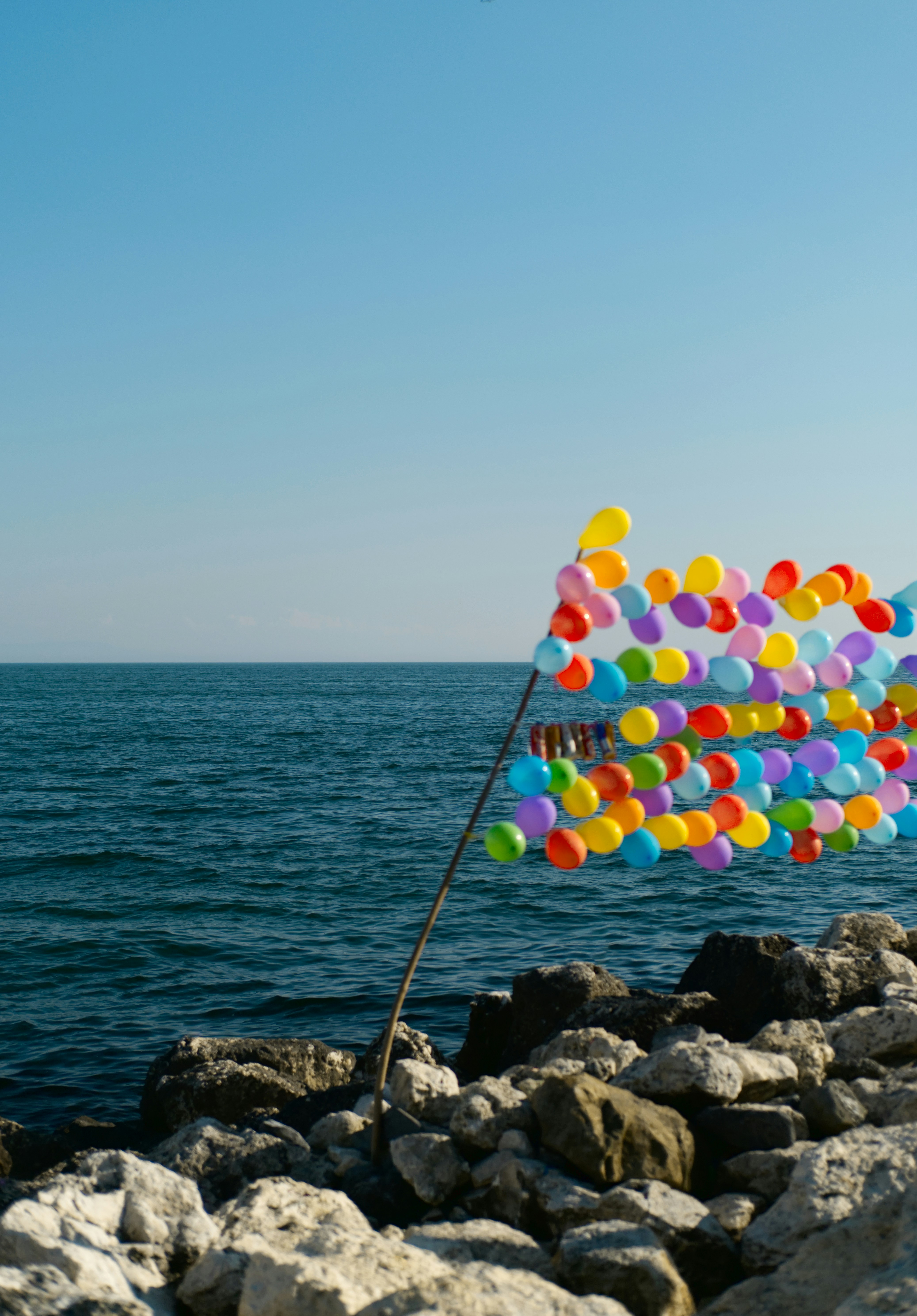 Colorful Balloons by the Sea: A Quiet Windward Moment