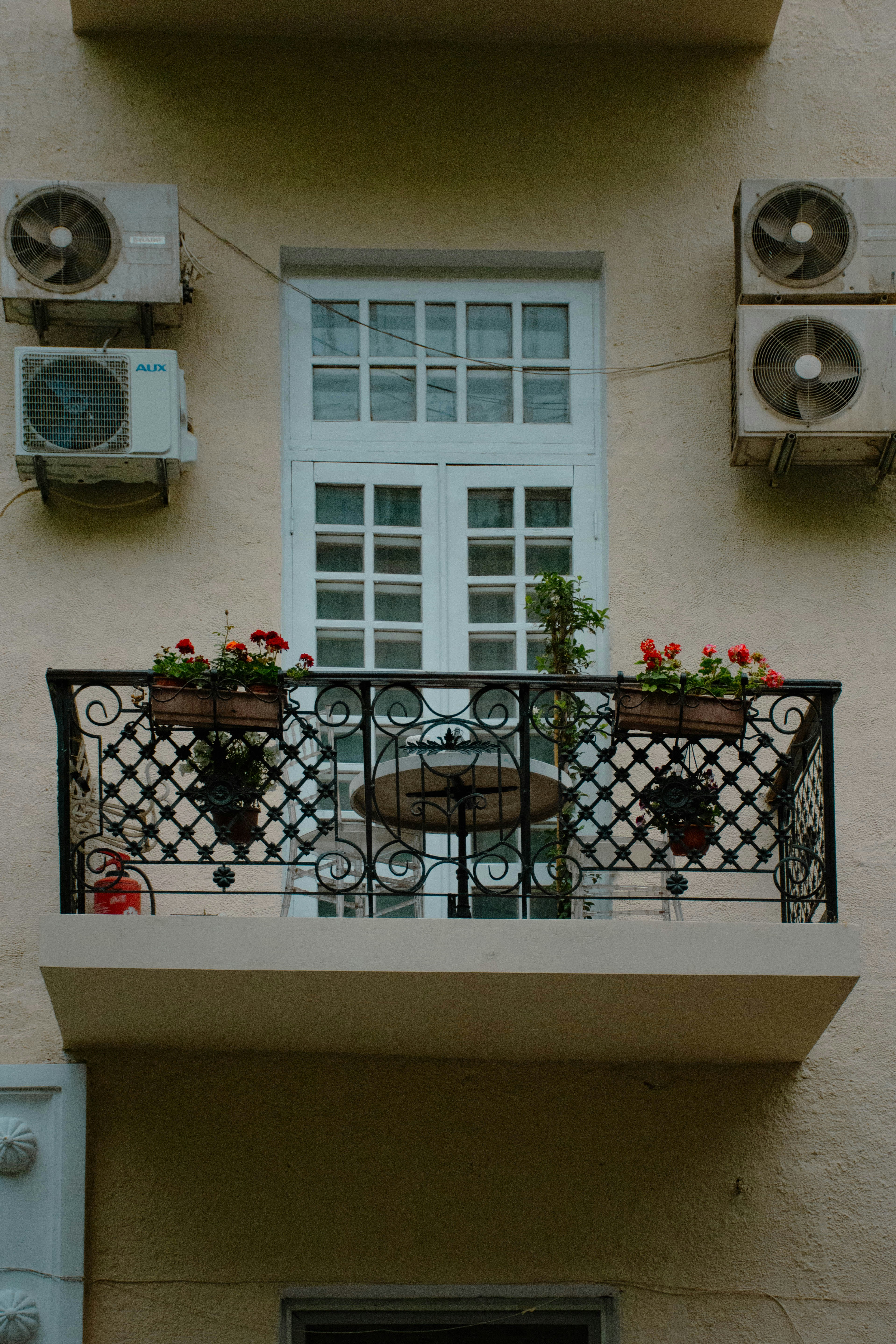 Floral Balcony Amid Air Conditioning Towers