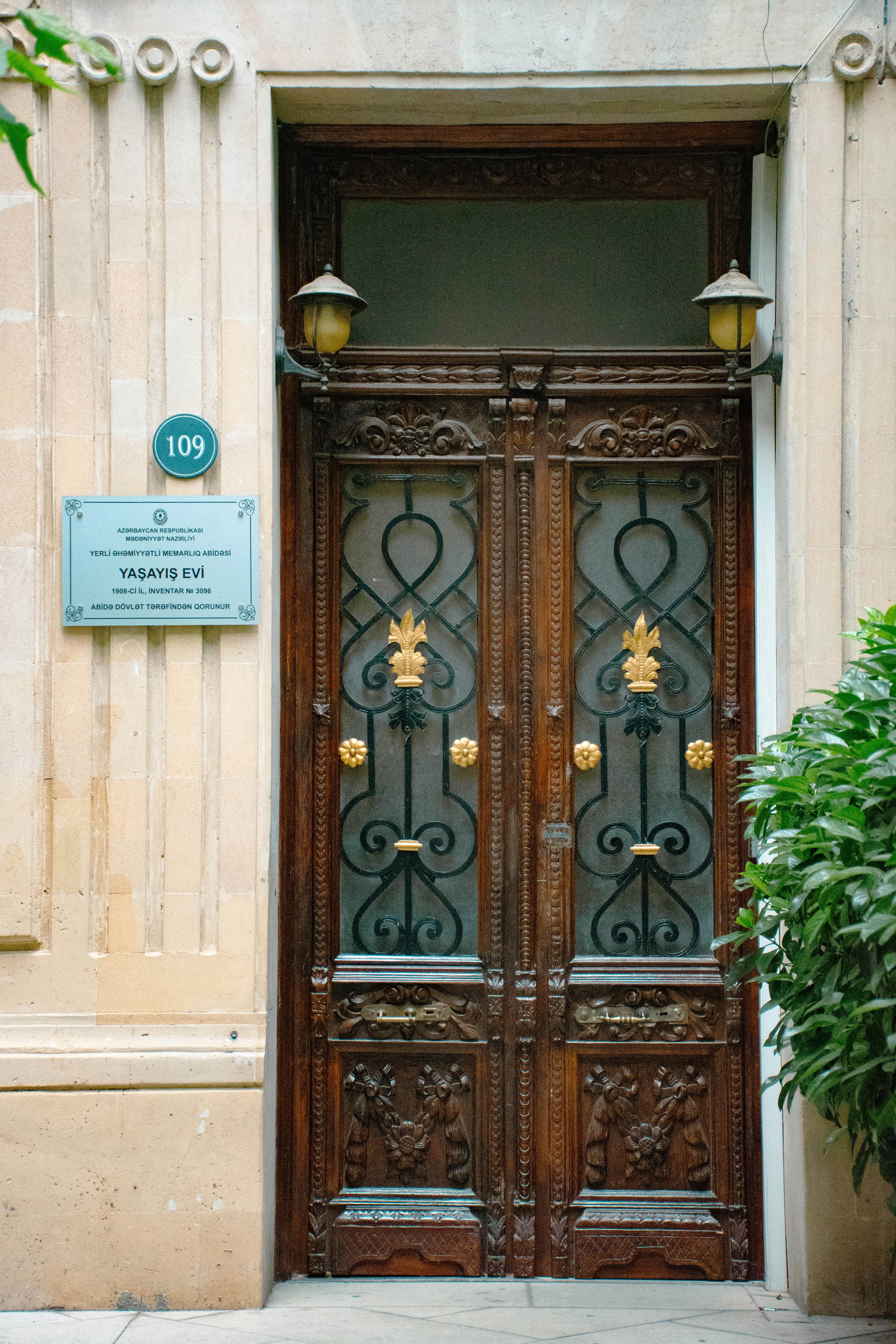 Ornate Doors of Yașayiş Evi: A Carved Portal in Sunlit Facade