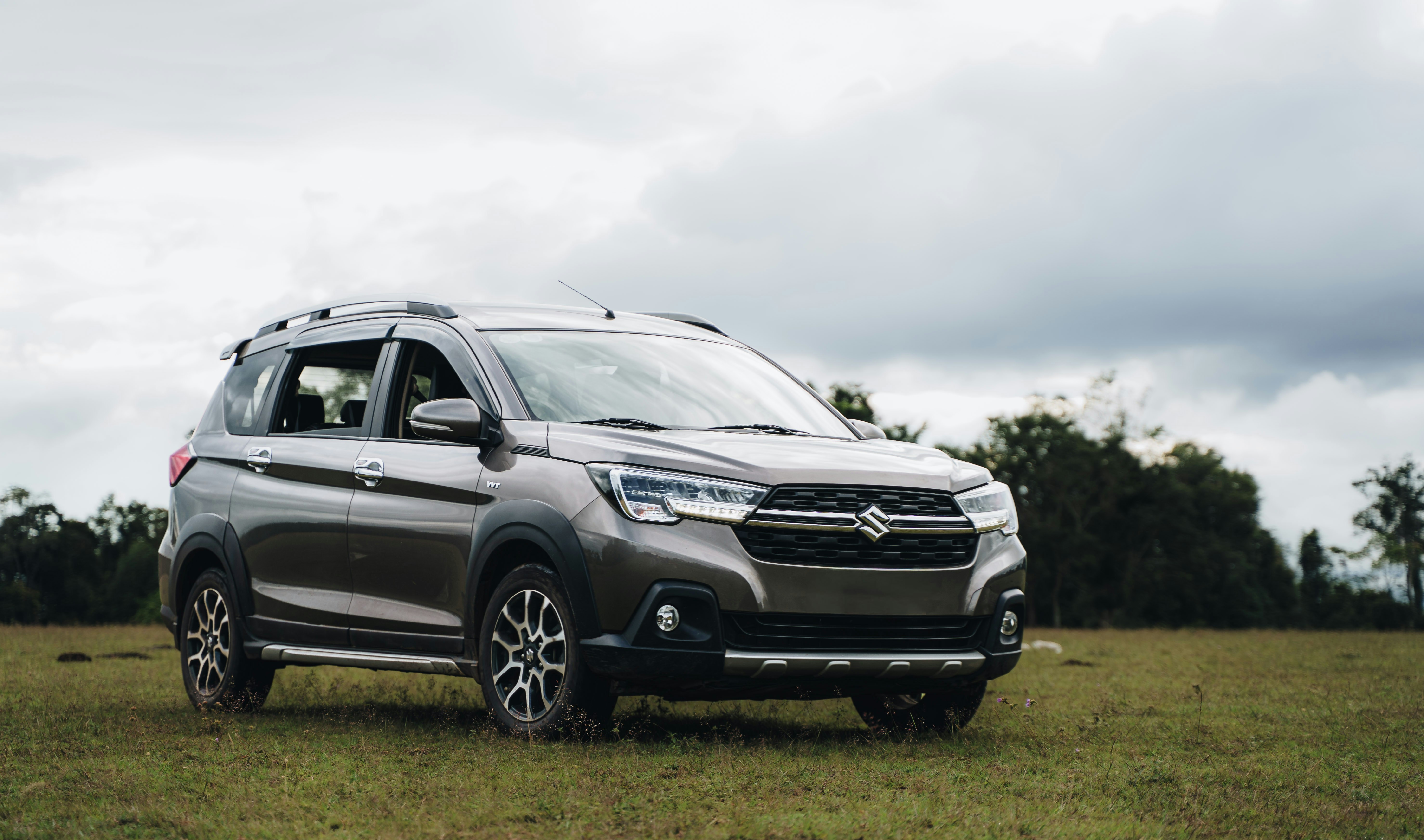 Desert Field Drive: Suzuki SUV Resting under a Stormy Sky