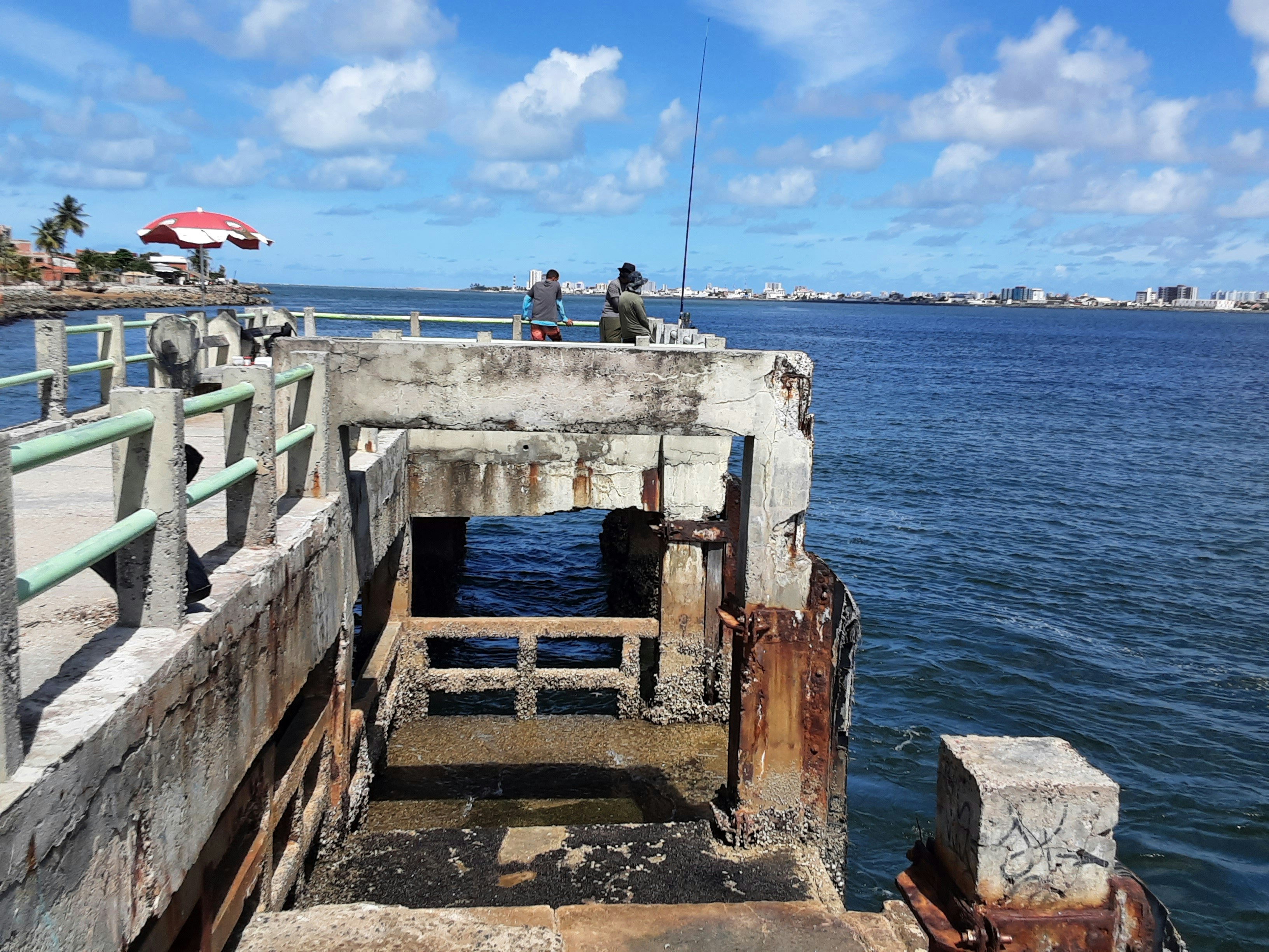 Pier Edge at Sea of Blue: Weathered Concrete and Distant City