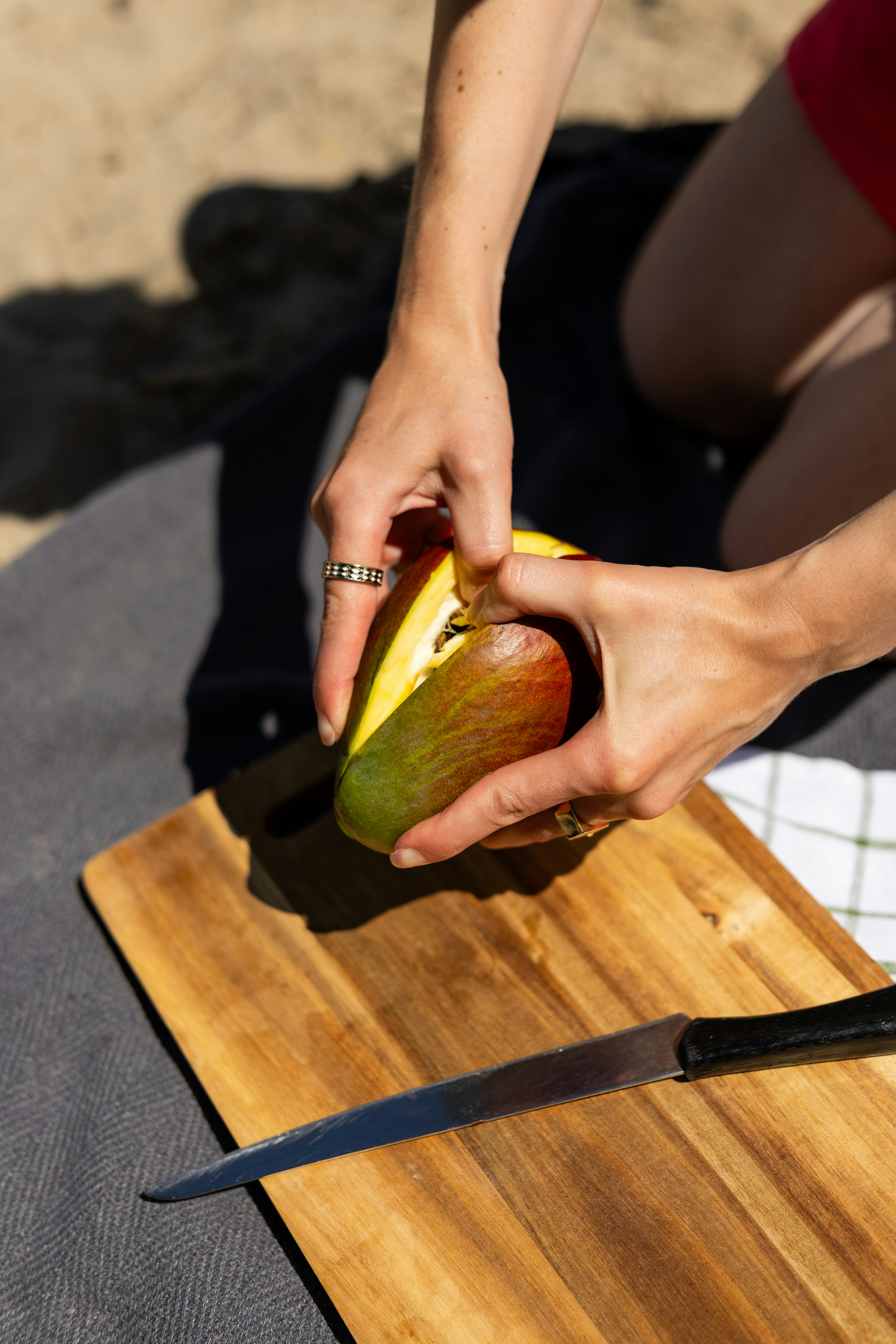 Hands at Work: Slicing a Mango on a Wooden Board