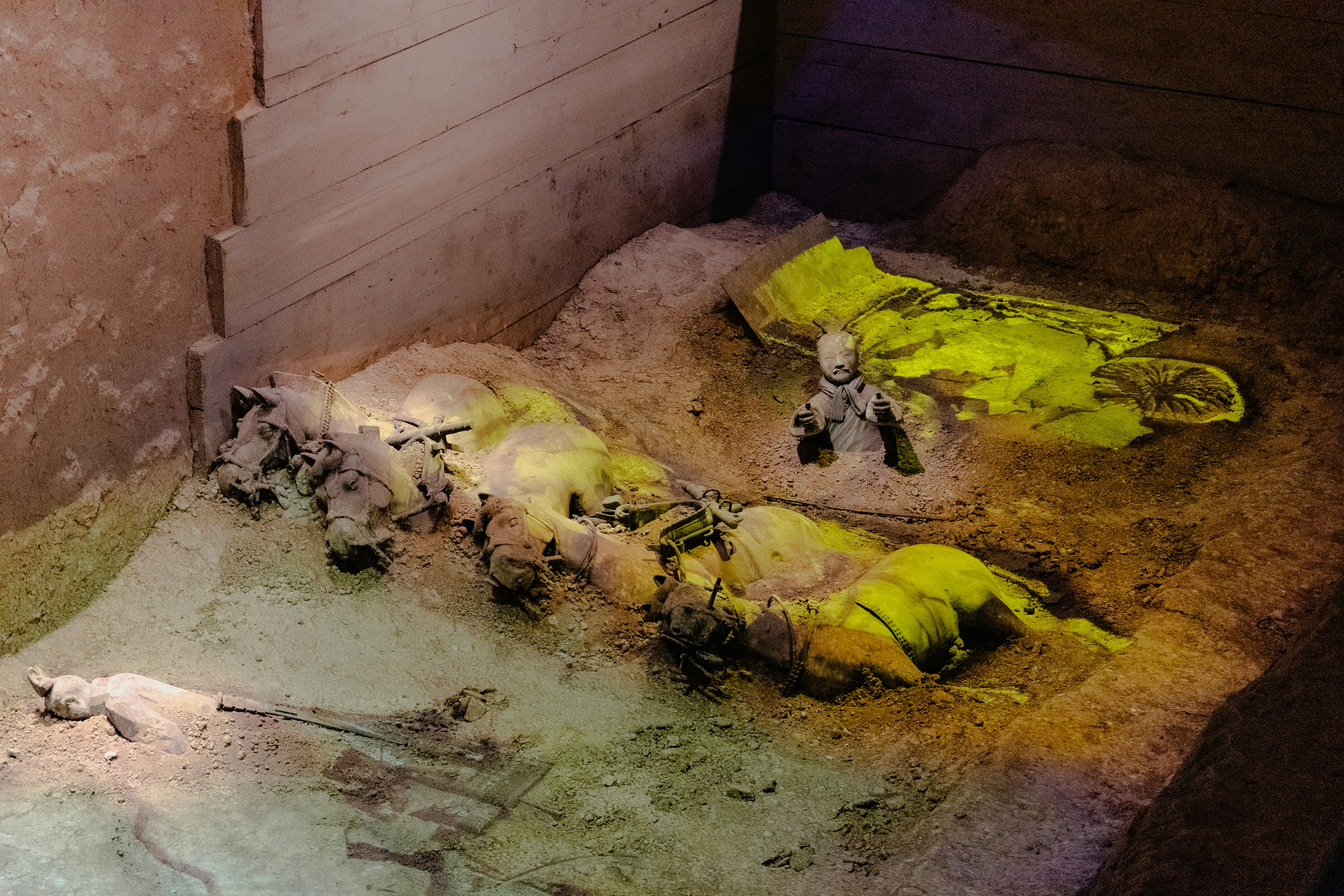 Dusty bunker sanctuary: scattered gear and a lone figure amid sand and shadows