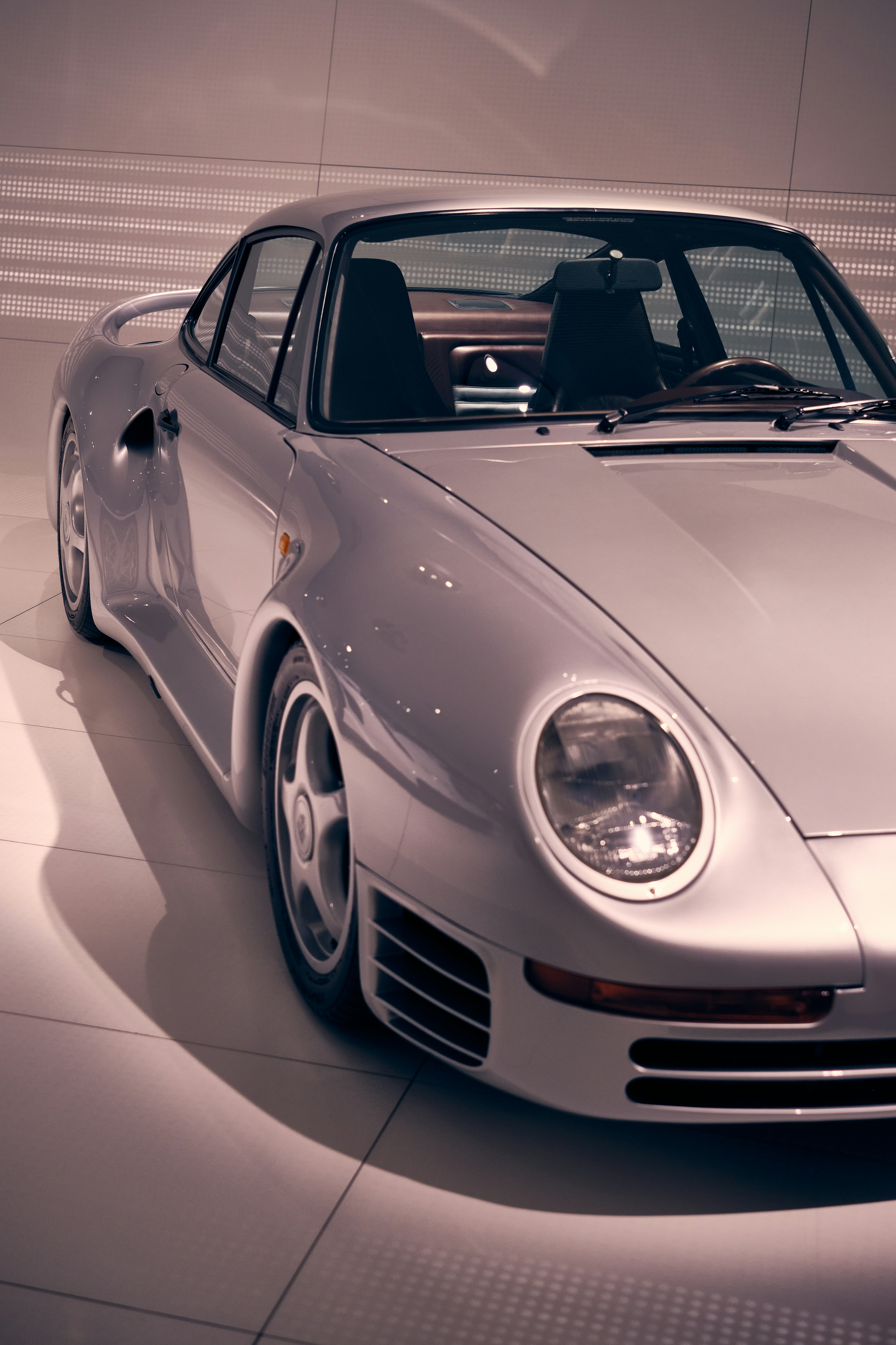 Pole-Backlit Classic: A Silver Porsche in an Elegant Gallery Corner