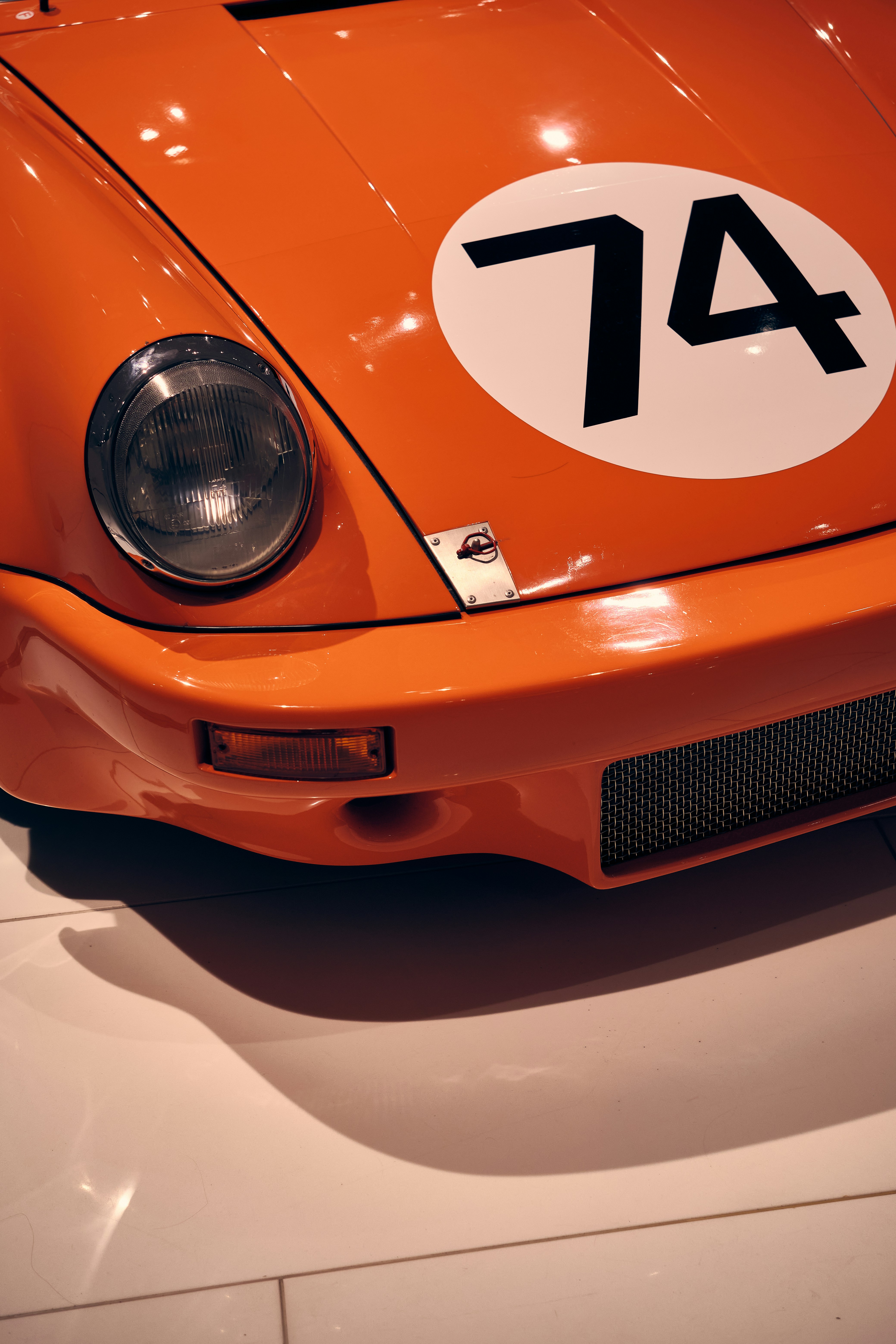 Racing Orange: The Front Quarter of a Classic Car with Bold Number 74