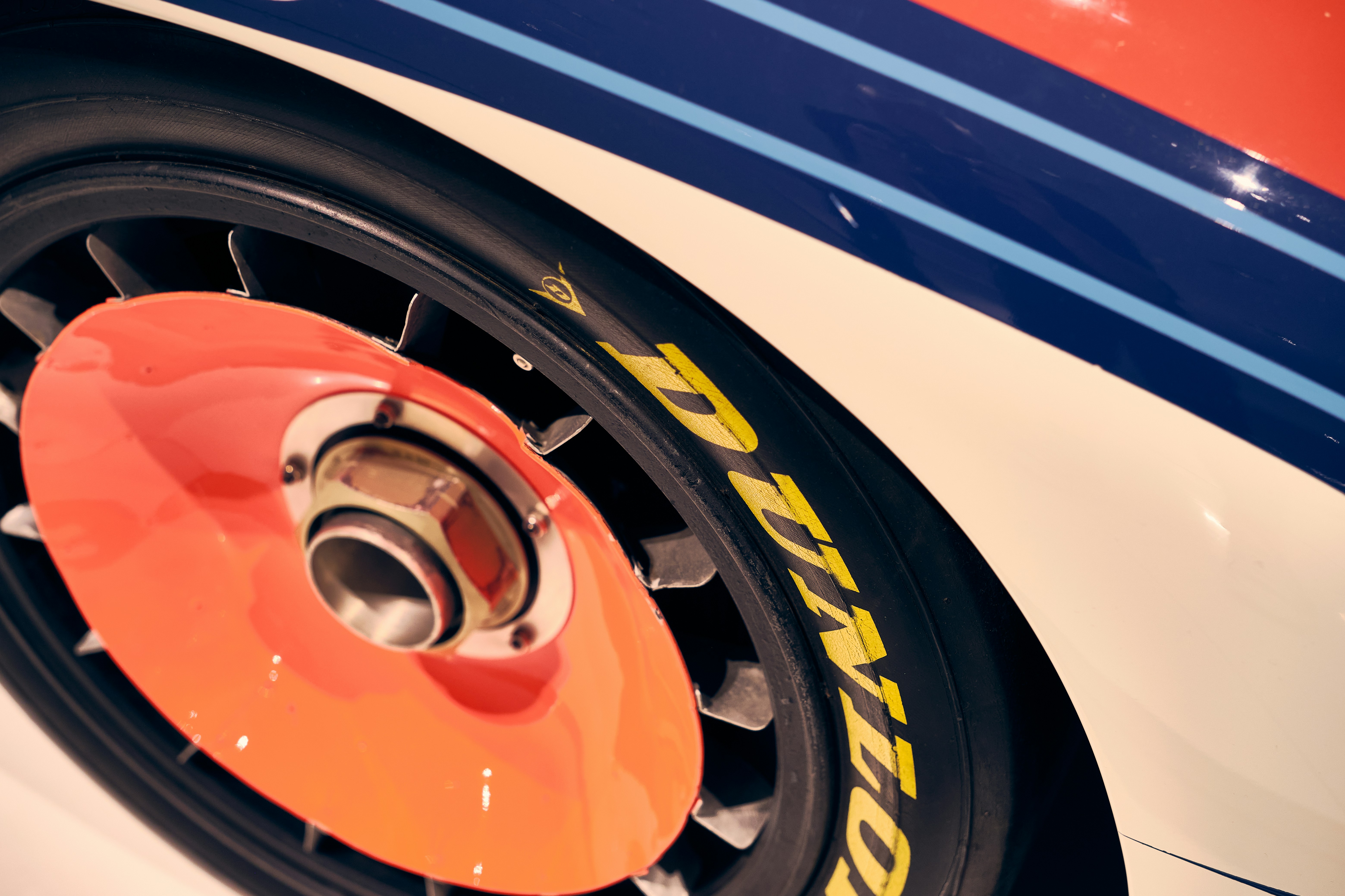 Orange hub and blue racing stripe: close-up of a vintage tire and wheel