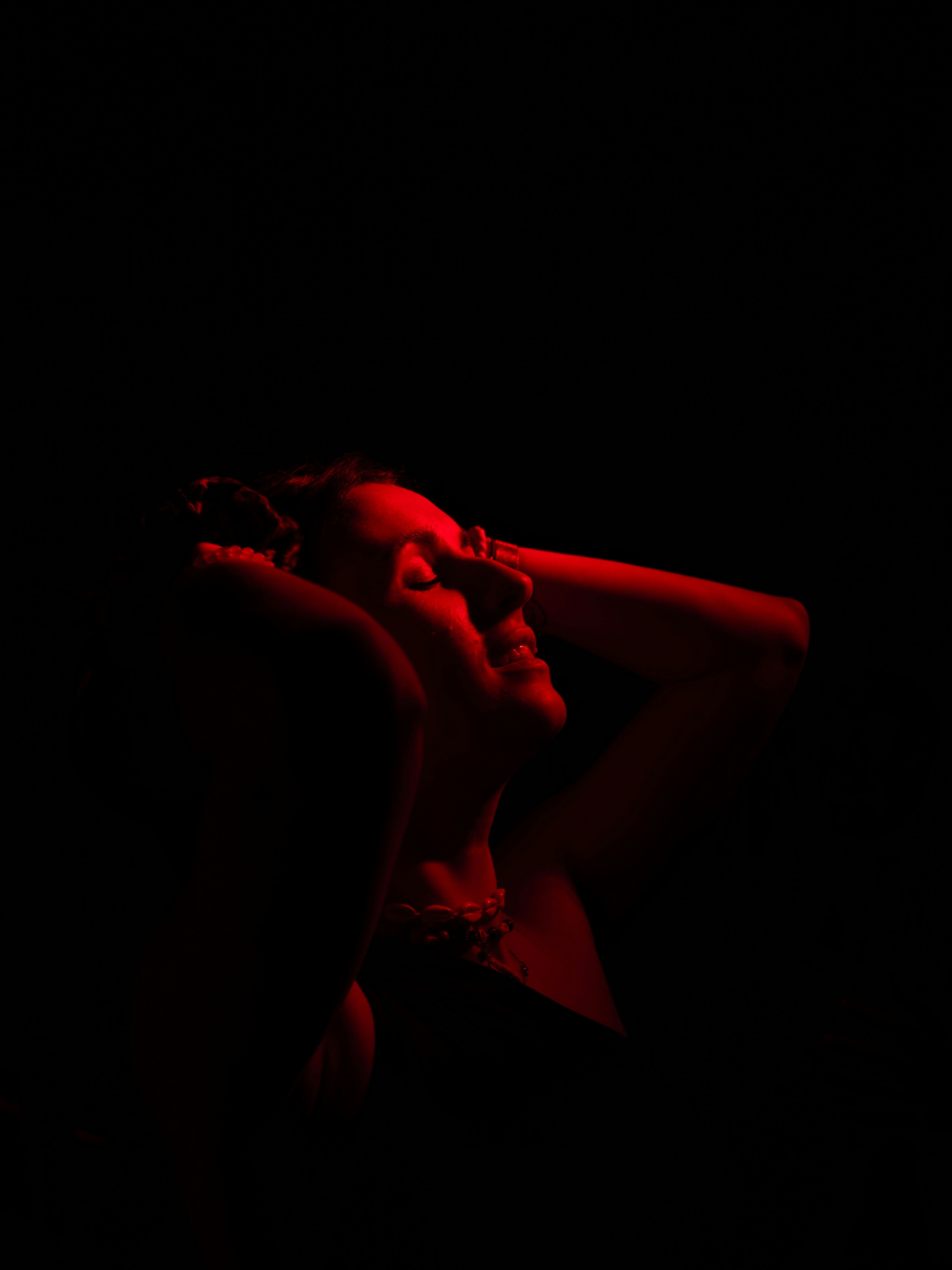Crimson Reverie: A Silhouette Pose in Low Light