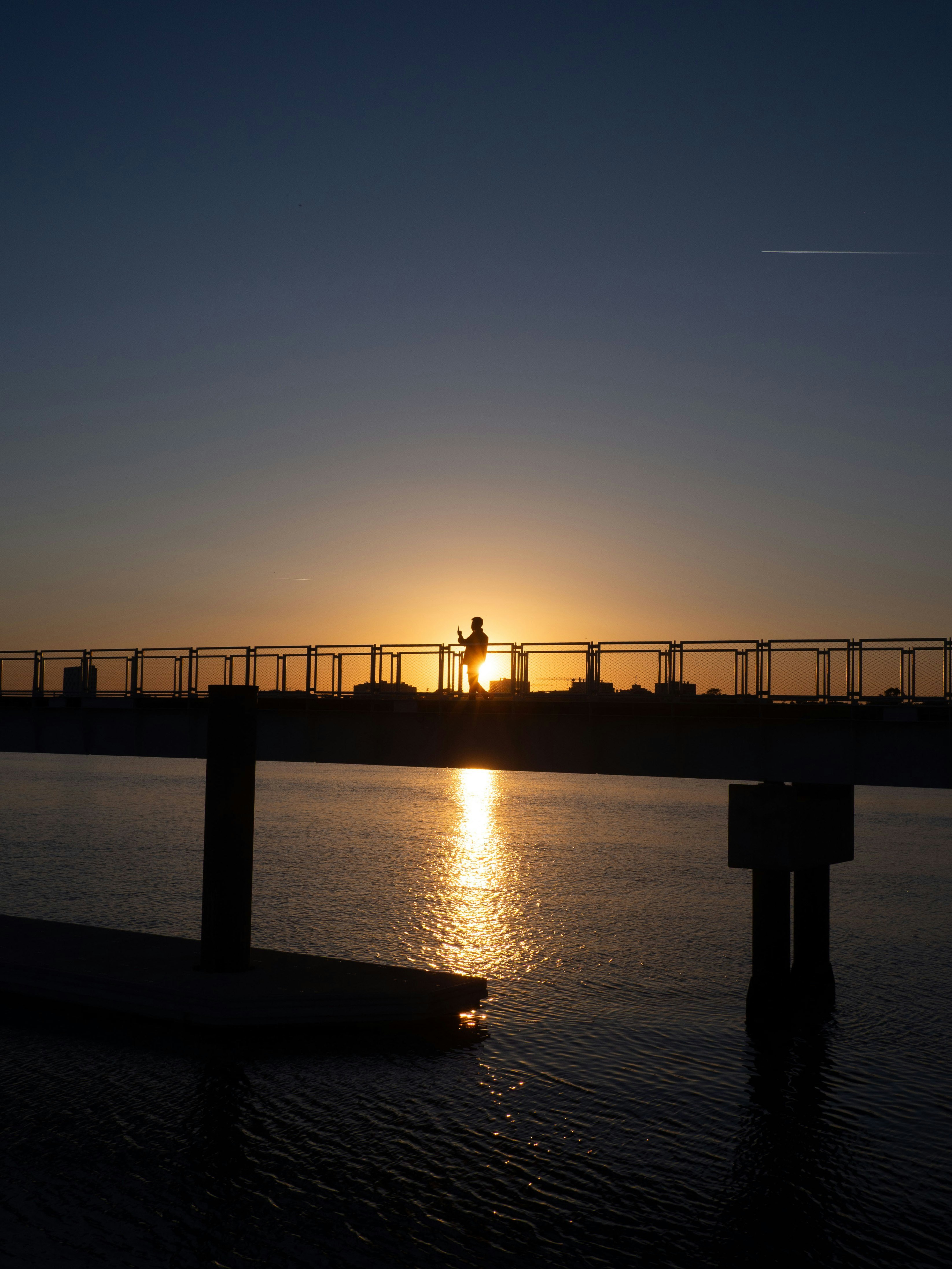 Silhouette on the Sunlit Pier at Golden Hour