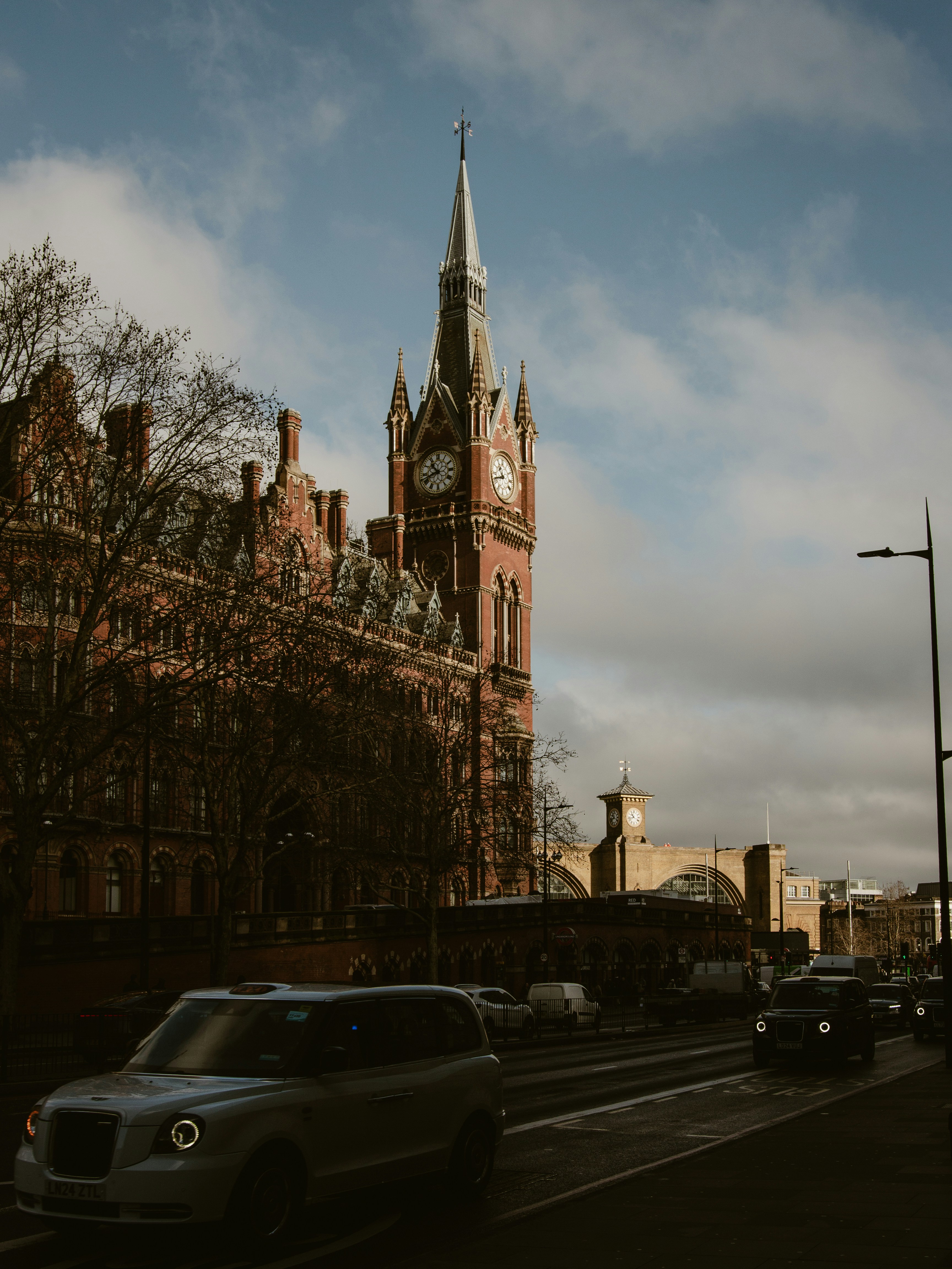 Gothic Clock Tower over a Busy City Street at Dusk