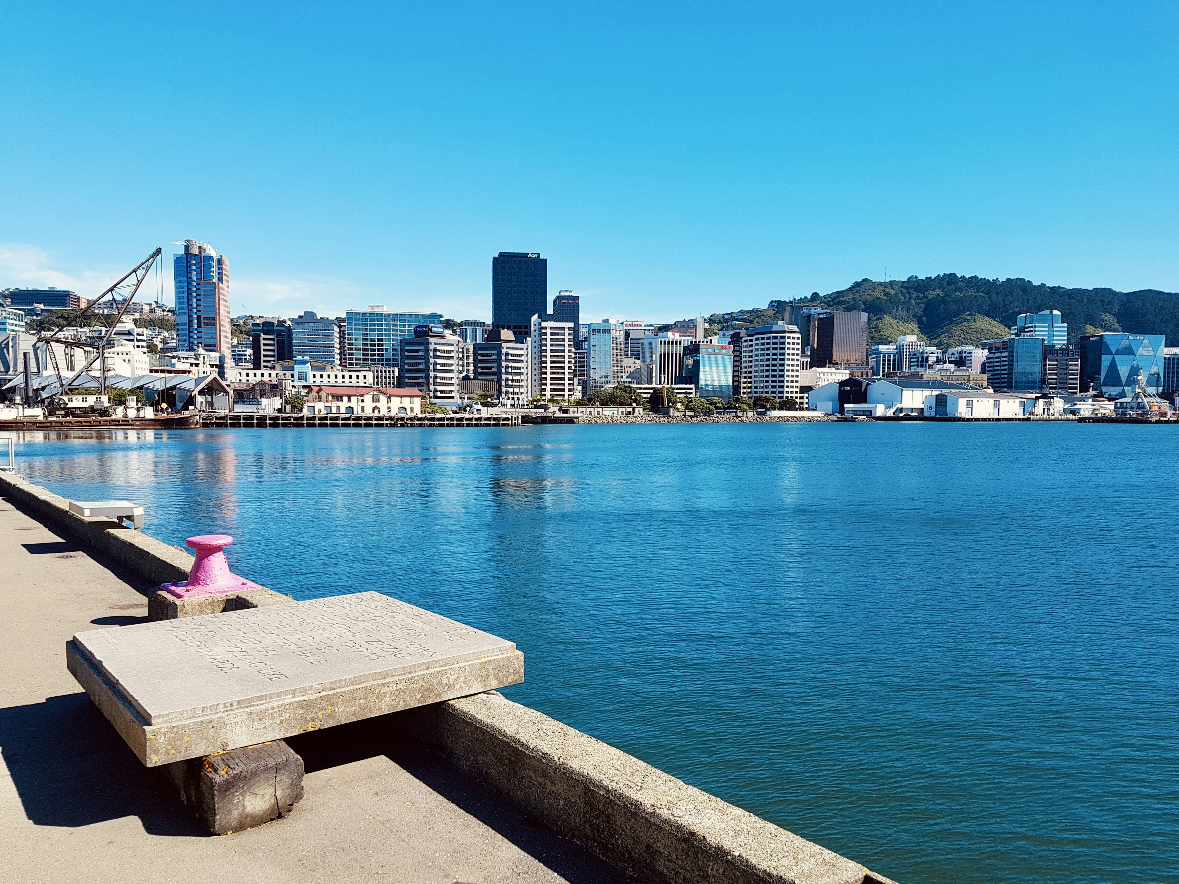 Harbor Skyline Beyond the Pier: A Bright Urban Wake