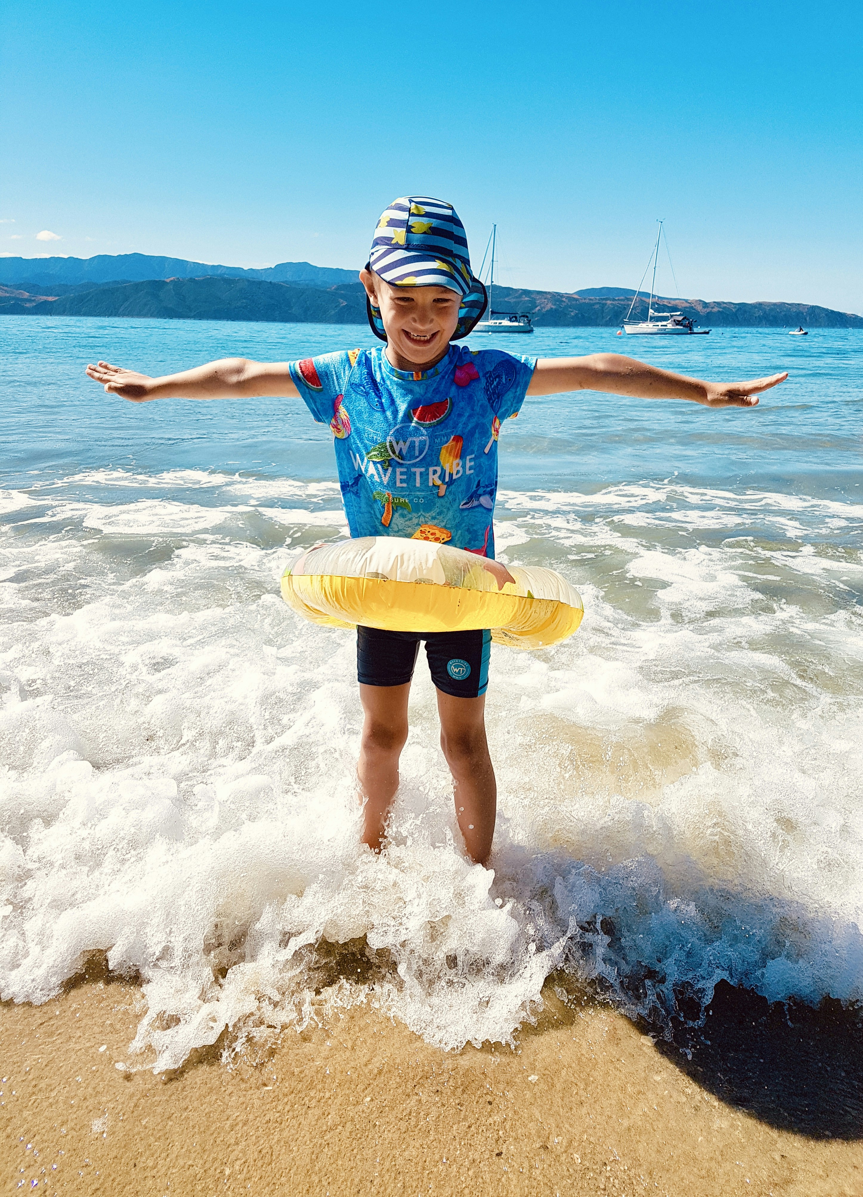 Joyful Beach Splash: A Child’s Outstretched Triumph at Sea