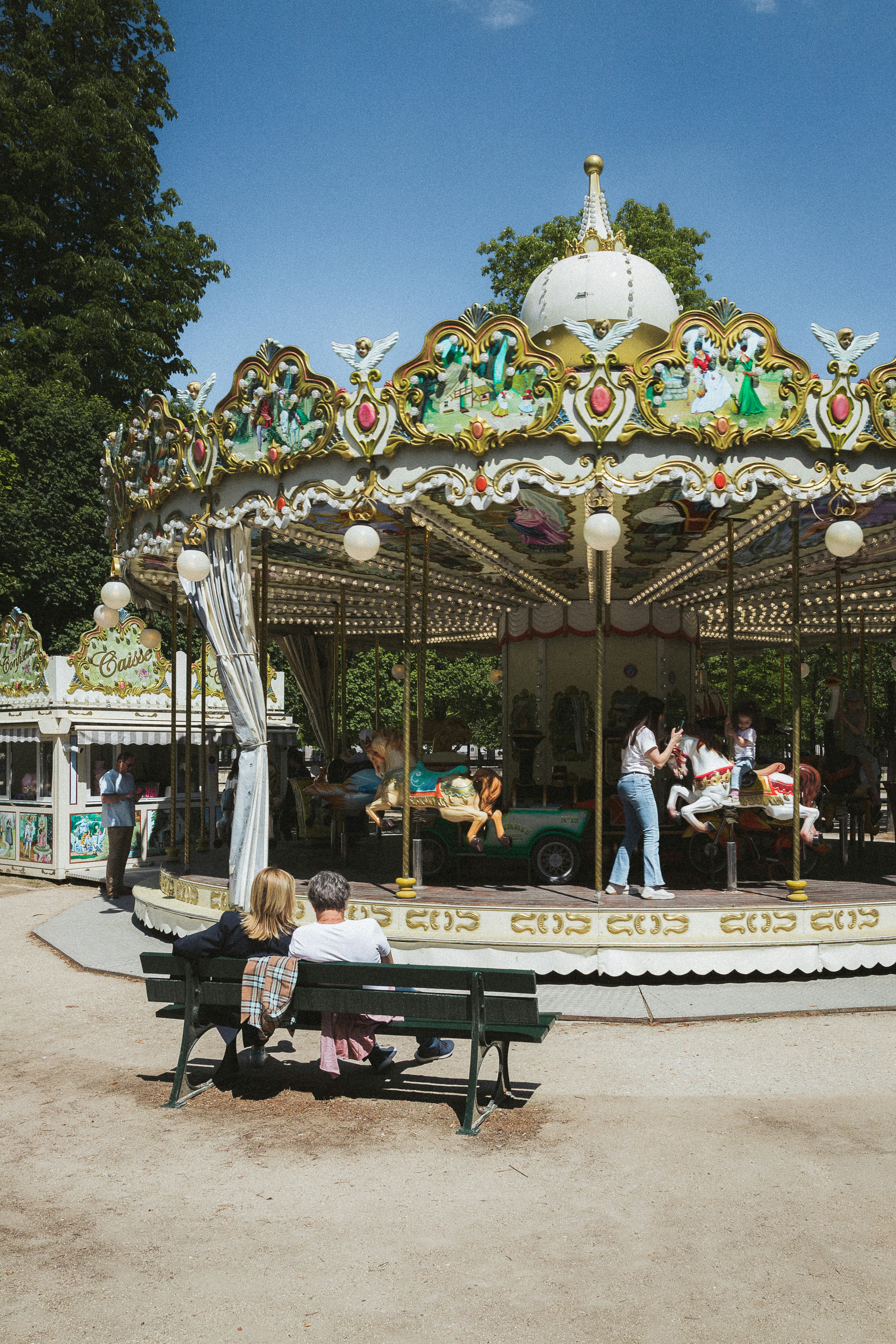 Carousel Bench beneath the Sun: Family Moments at a Vintage Park Ride