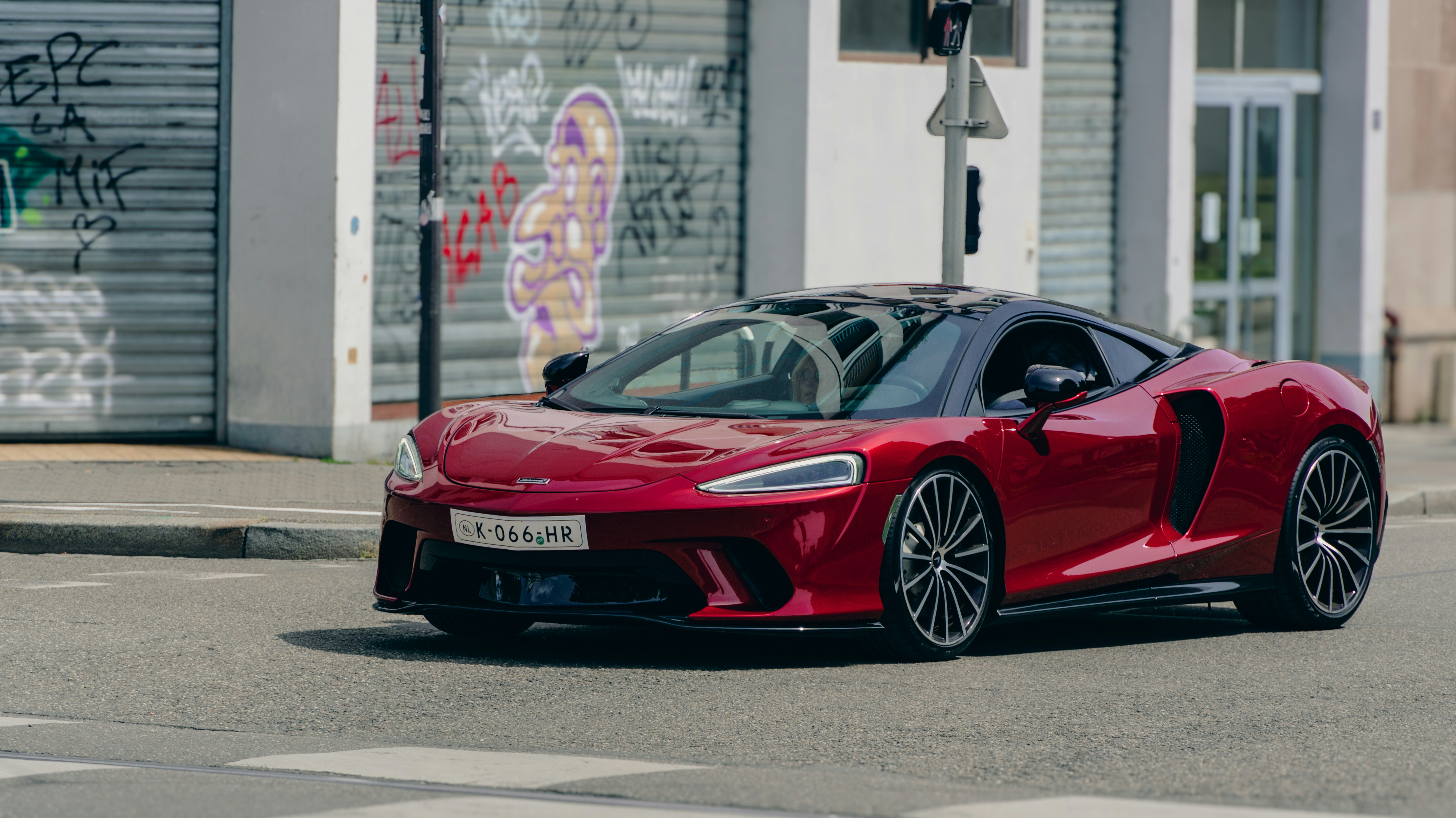 Crimson Thunder: A Red Ferrari Rolls Through City Graffiti