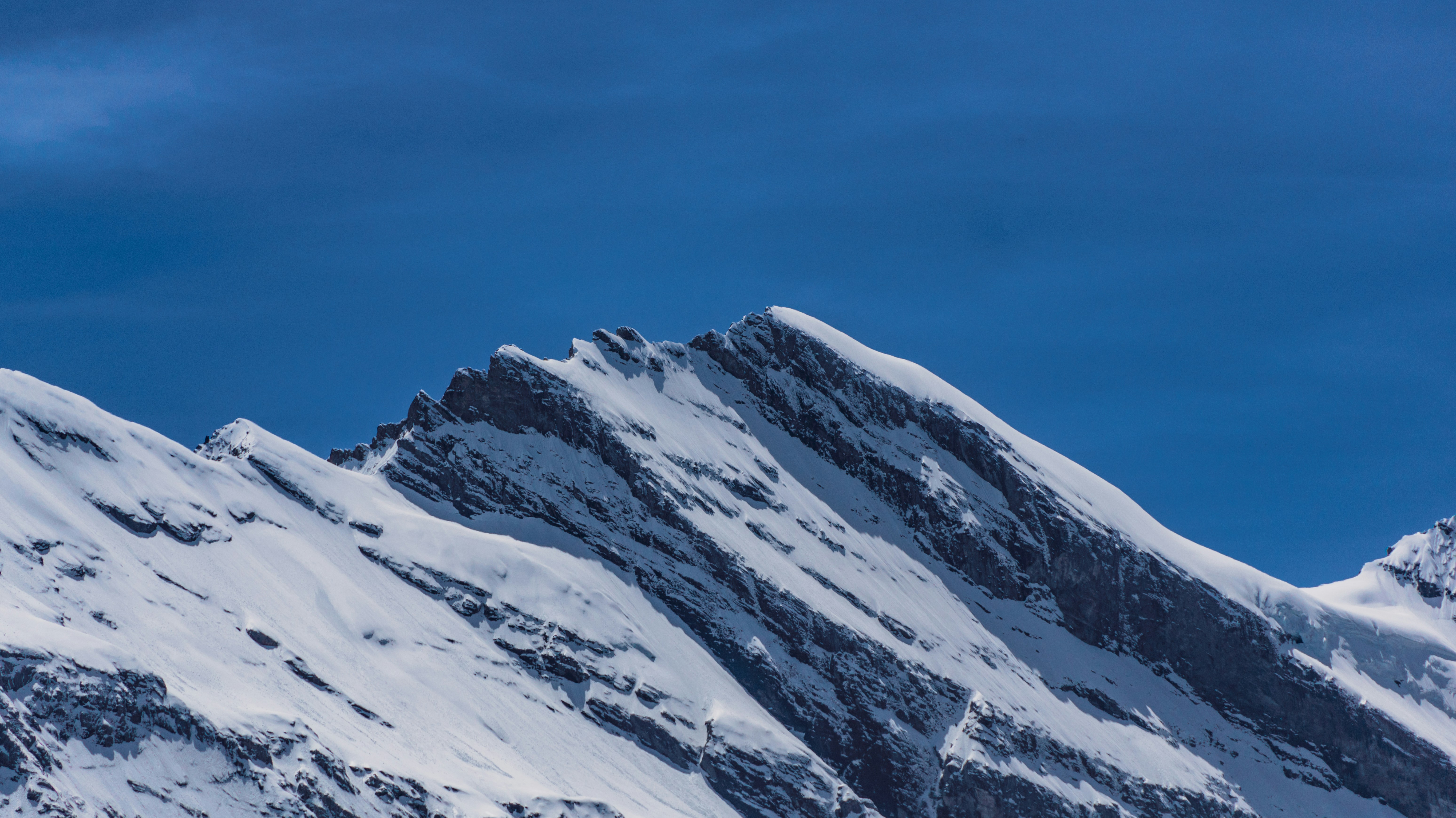 Apex of Silence: Snow-Crowned Peaks Under a Clear Blue Sky