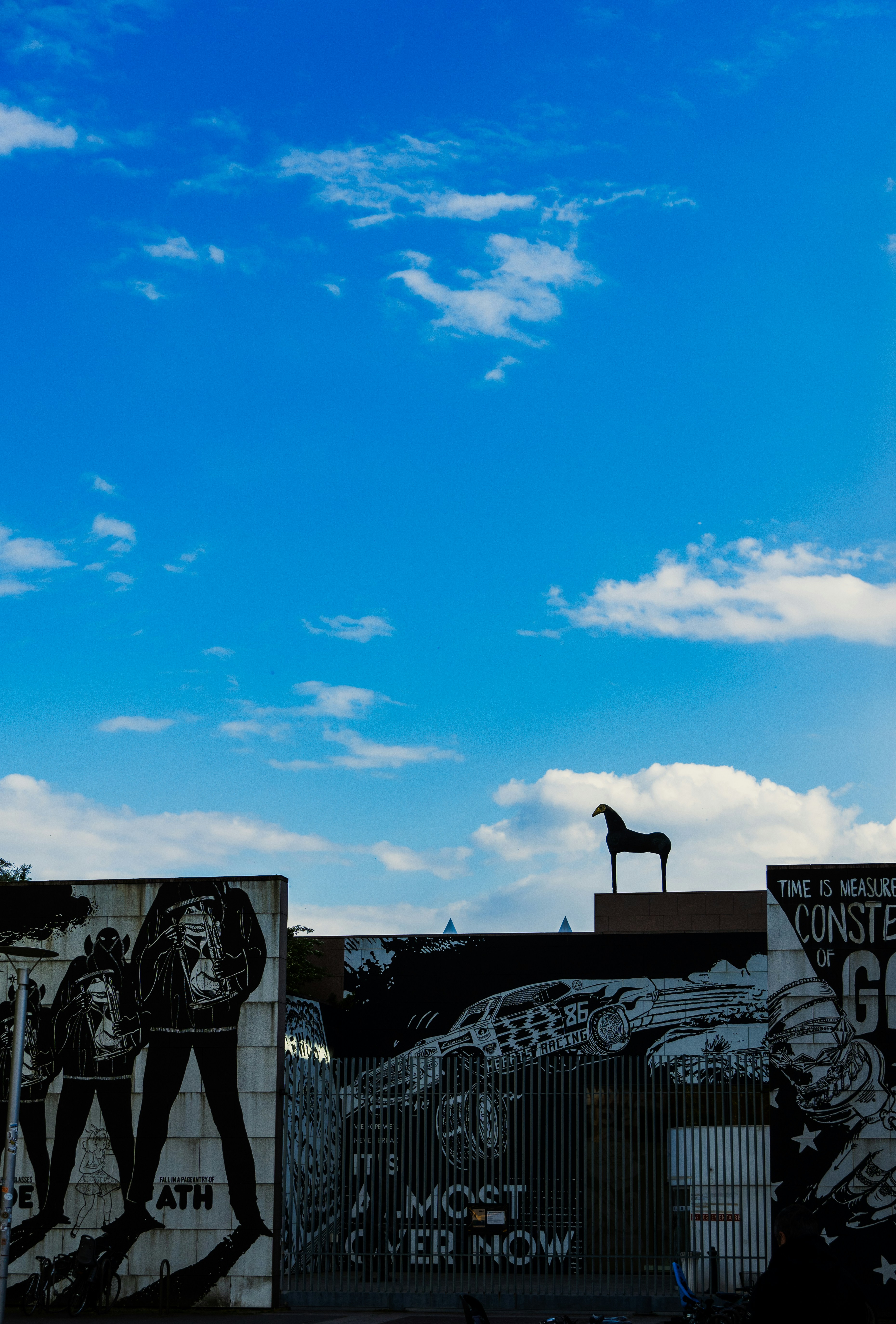 Sky Over Street Art: A Lone Horse Silhouette above Graffiti Walls