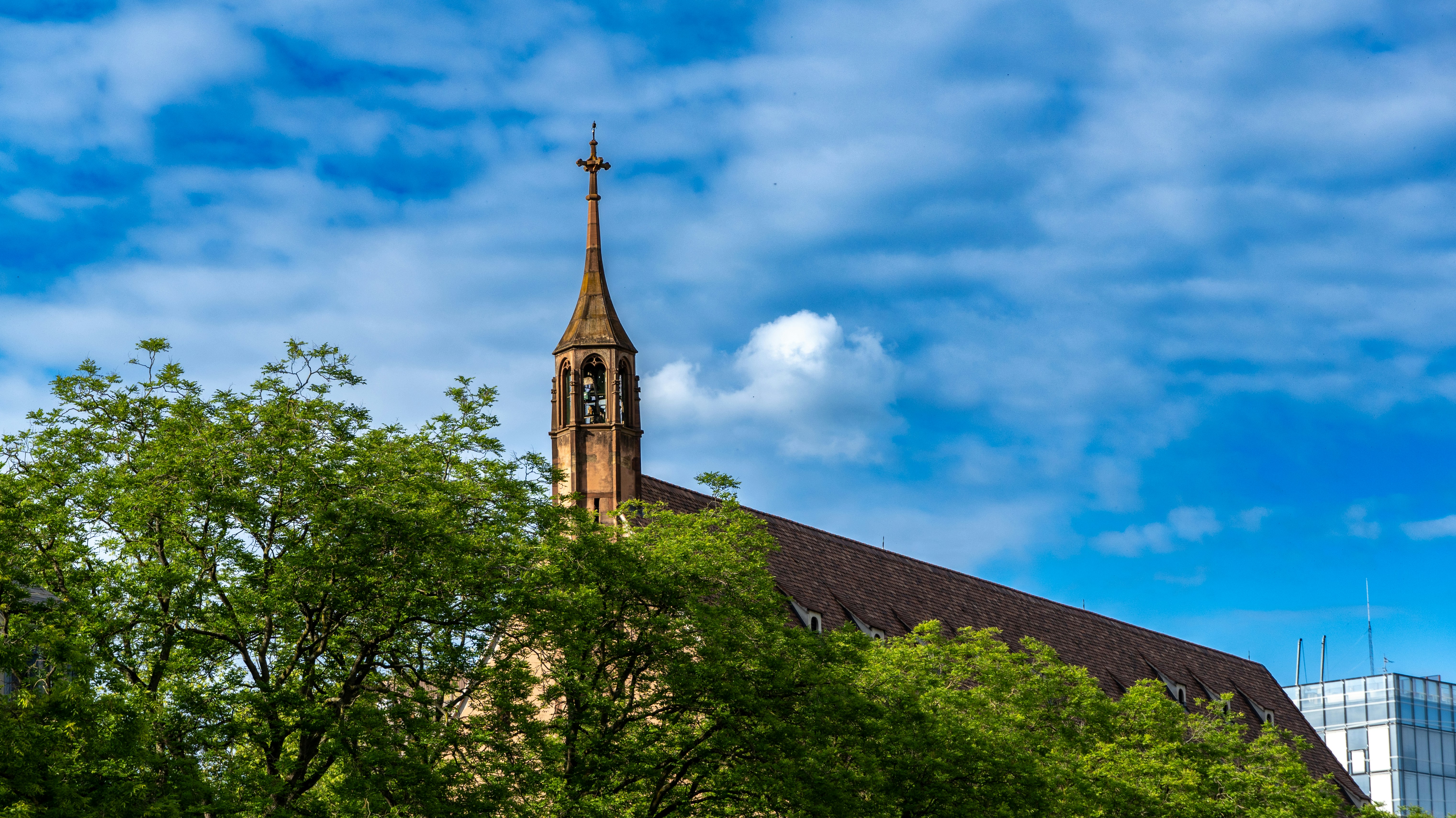 Towering Spire Above Verdant Rooflines